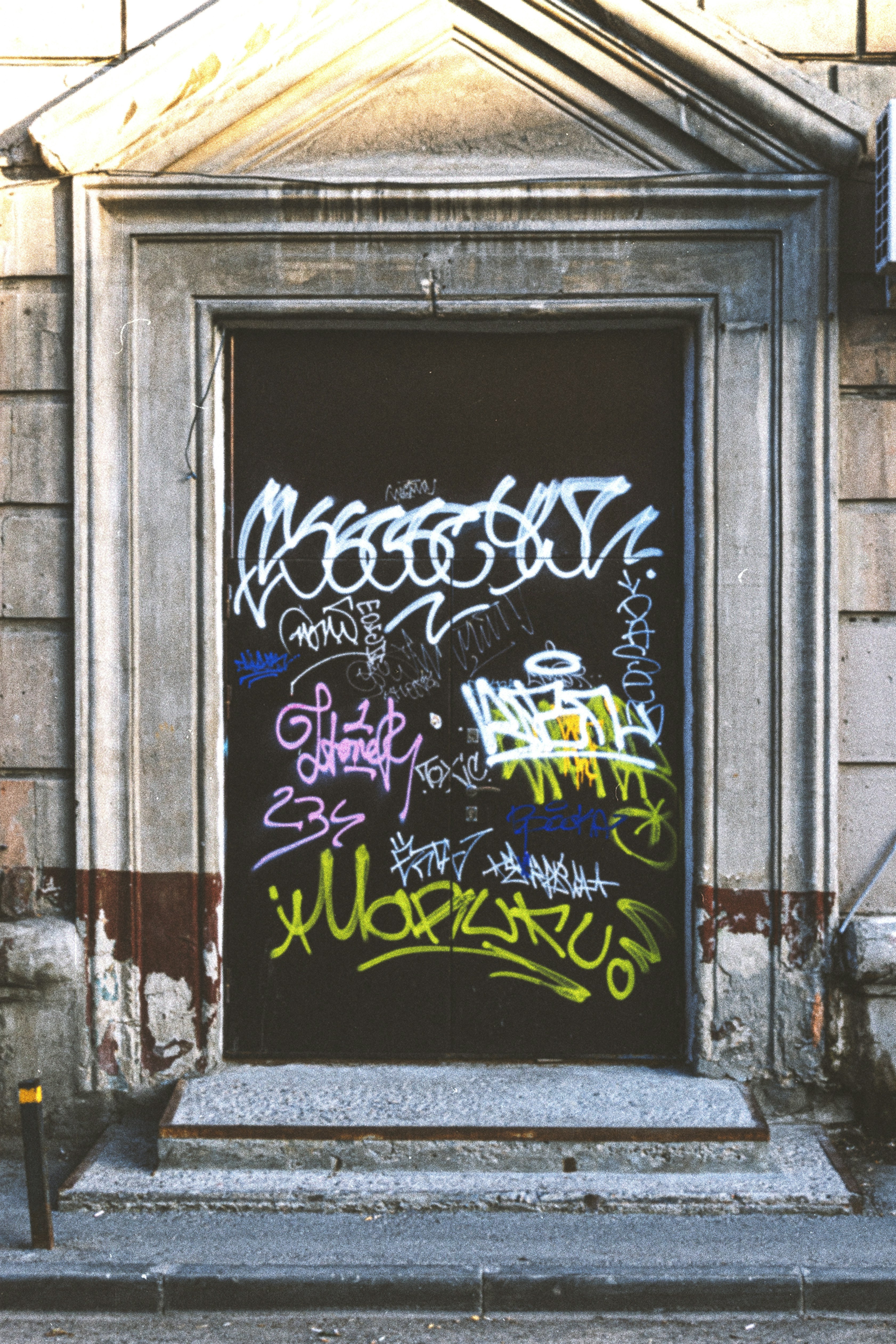 A door covered in graffiti in front of a building photo – Free Wall ...