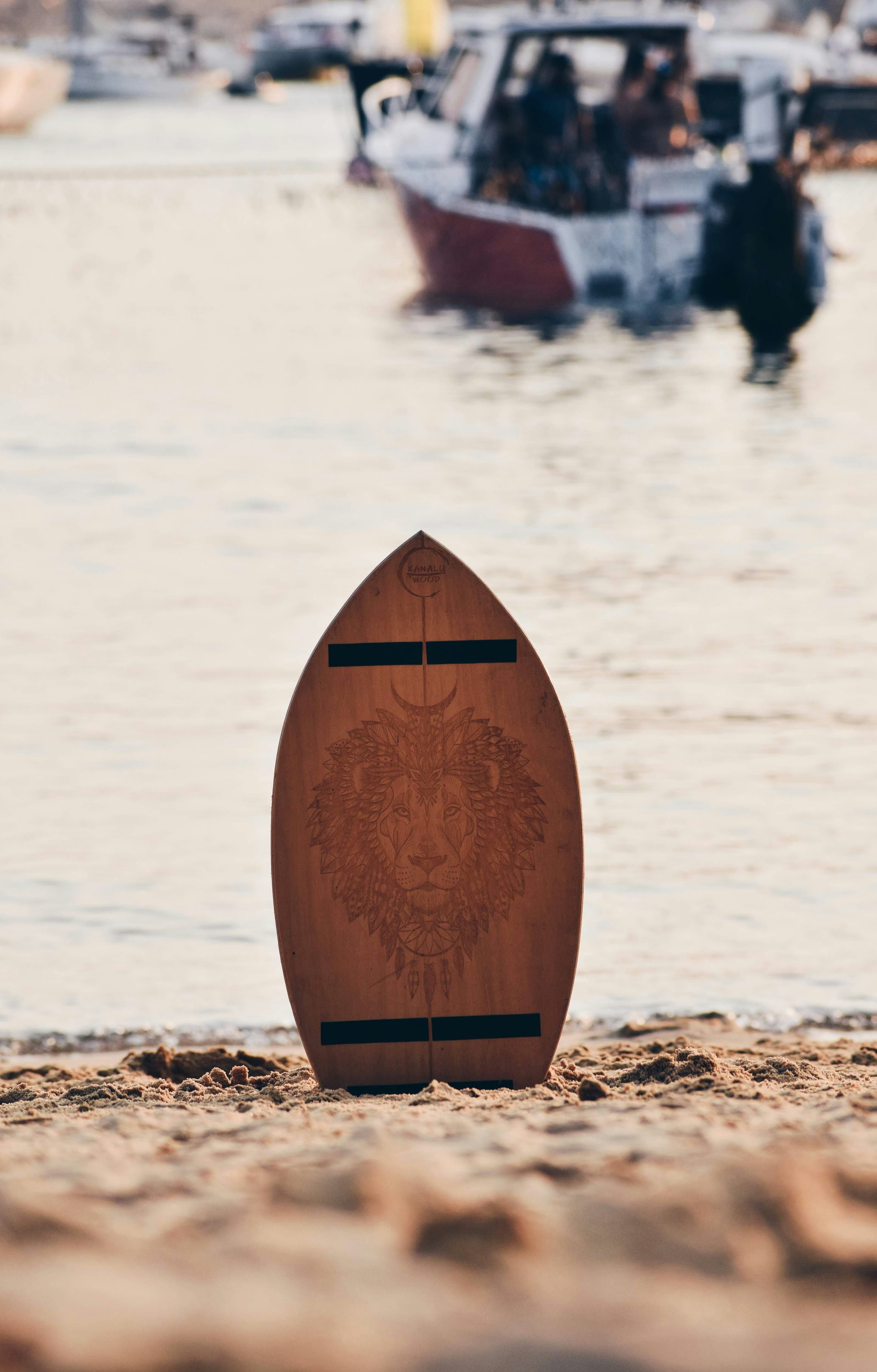 A brown surfboard sitting on top of a sandy beach photo – Free Manly ...