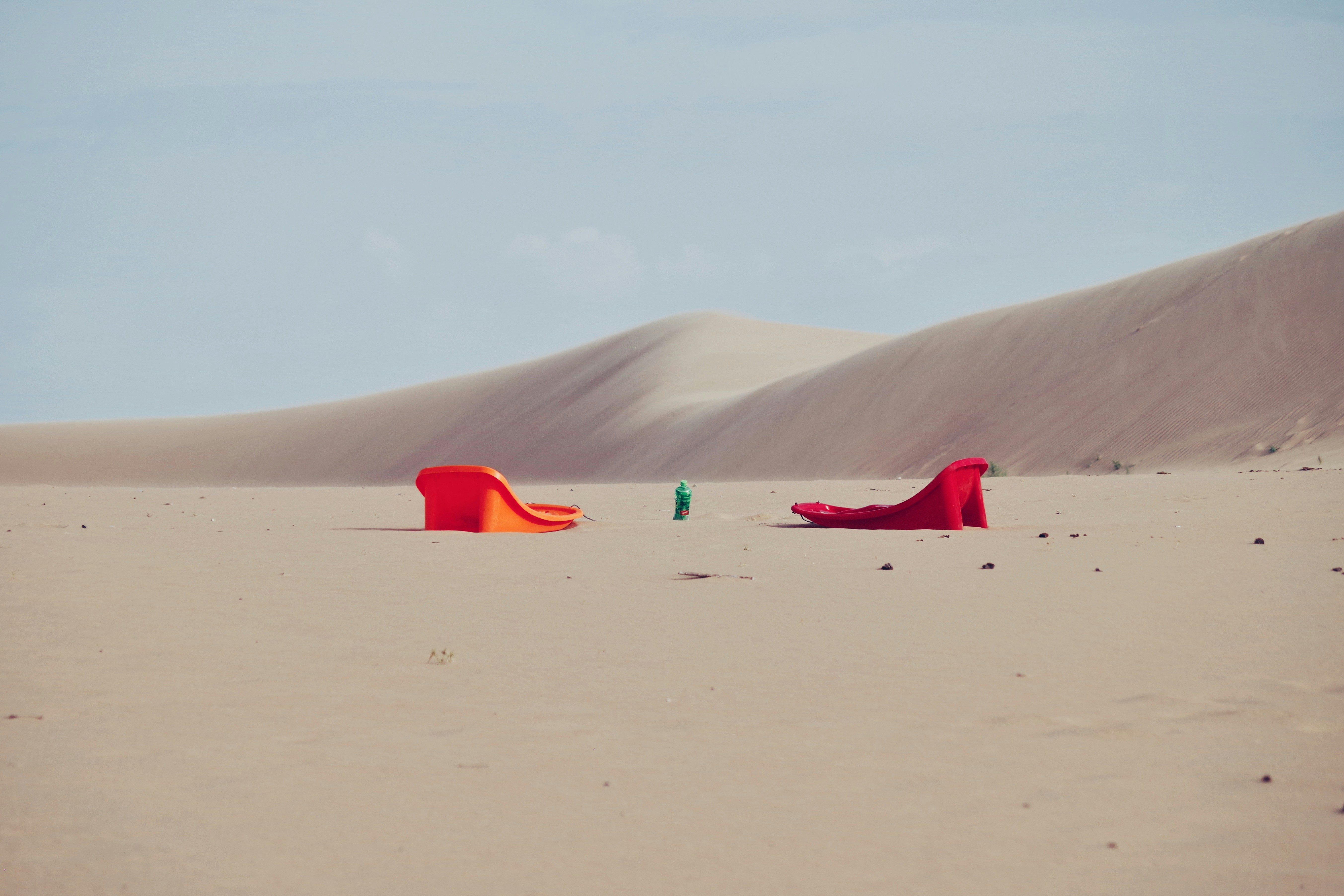 Twin Red Sails on a Quiet Dune, with a Lone Green Figure