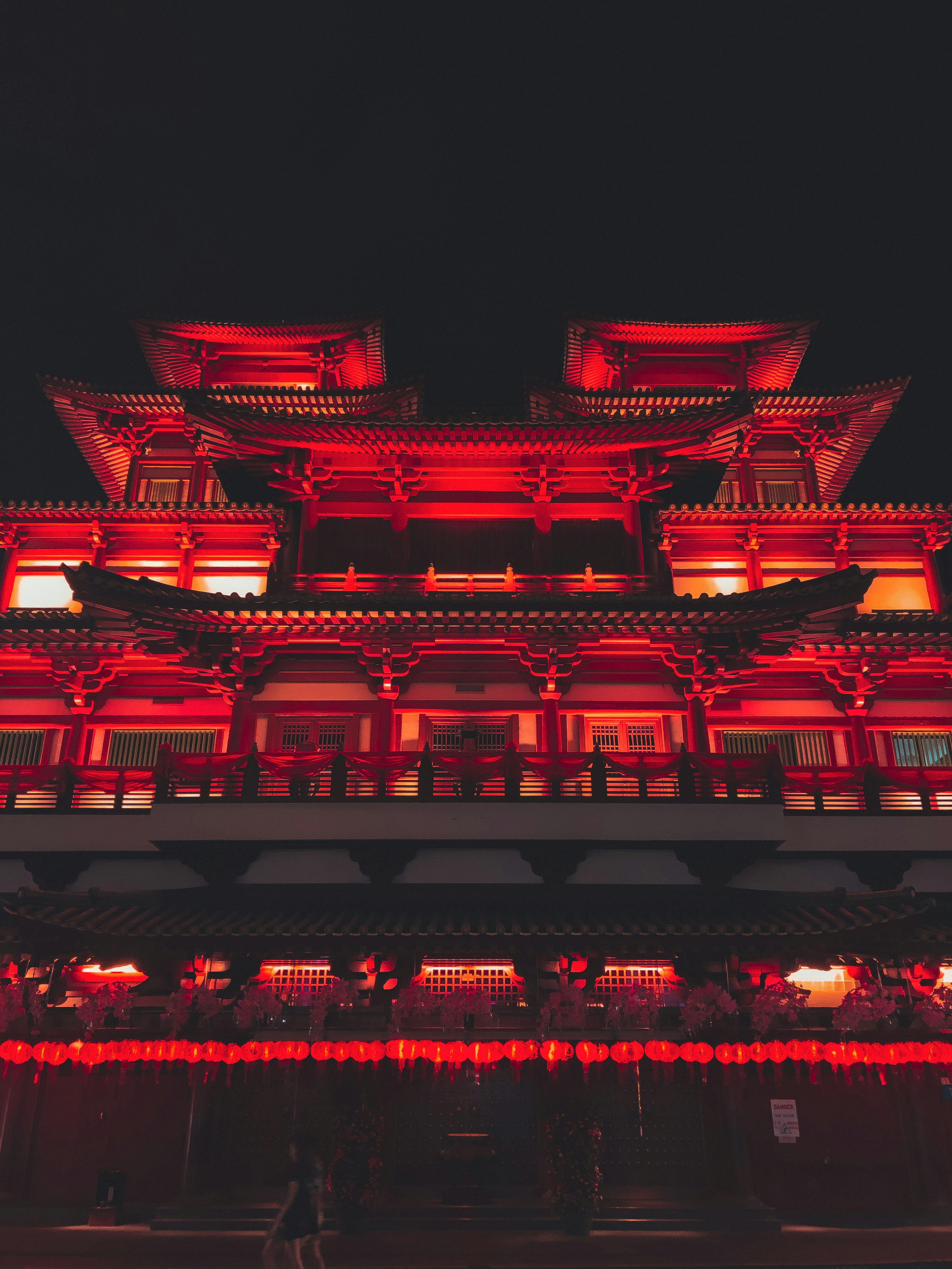 A tall building with red lights on top of it photo – Free Singapore ...