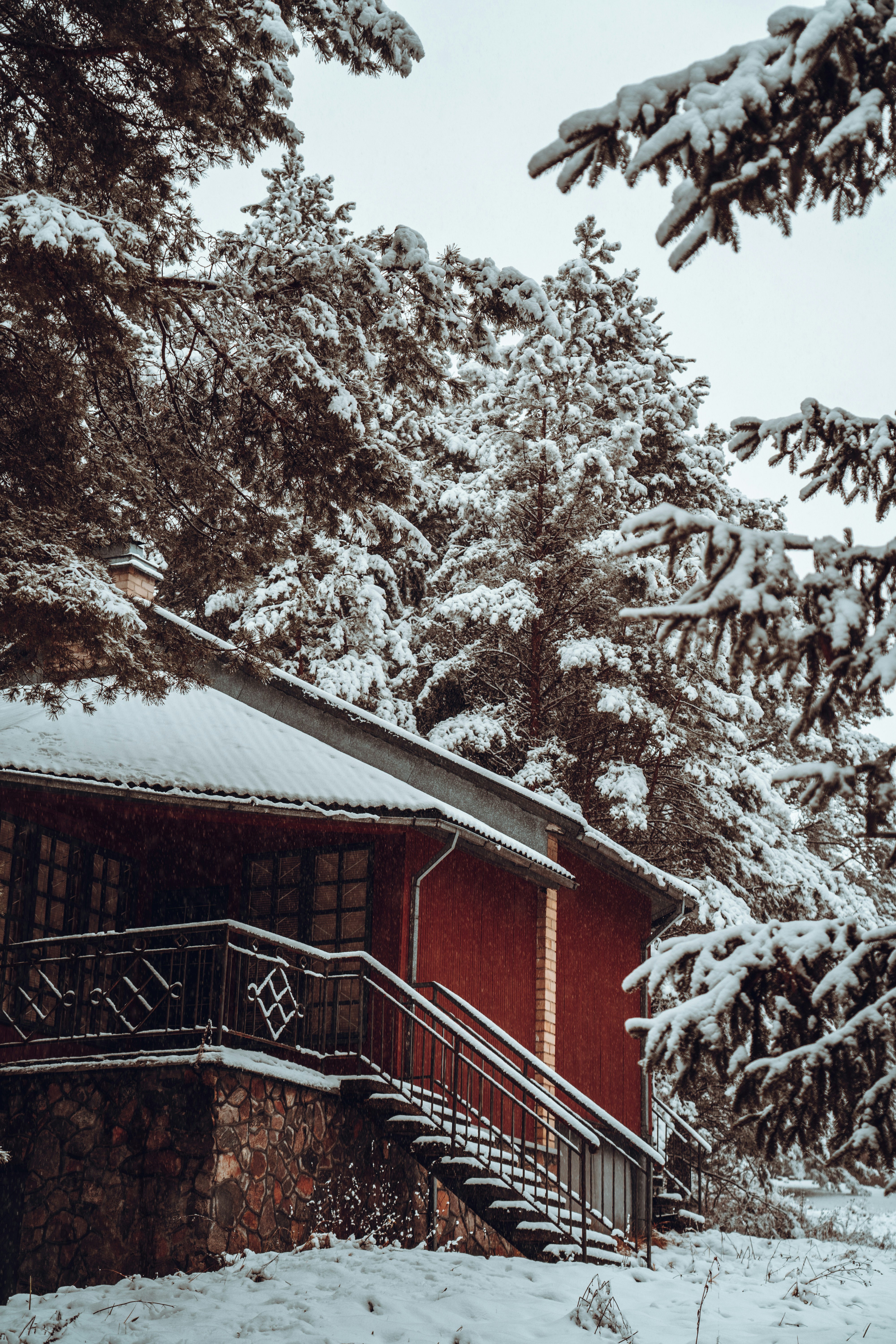 A red building surrounded by snow covered trees photo – Free House ...