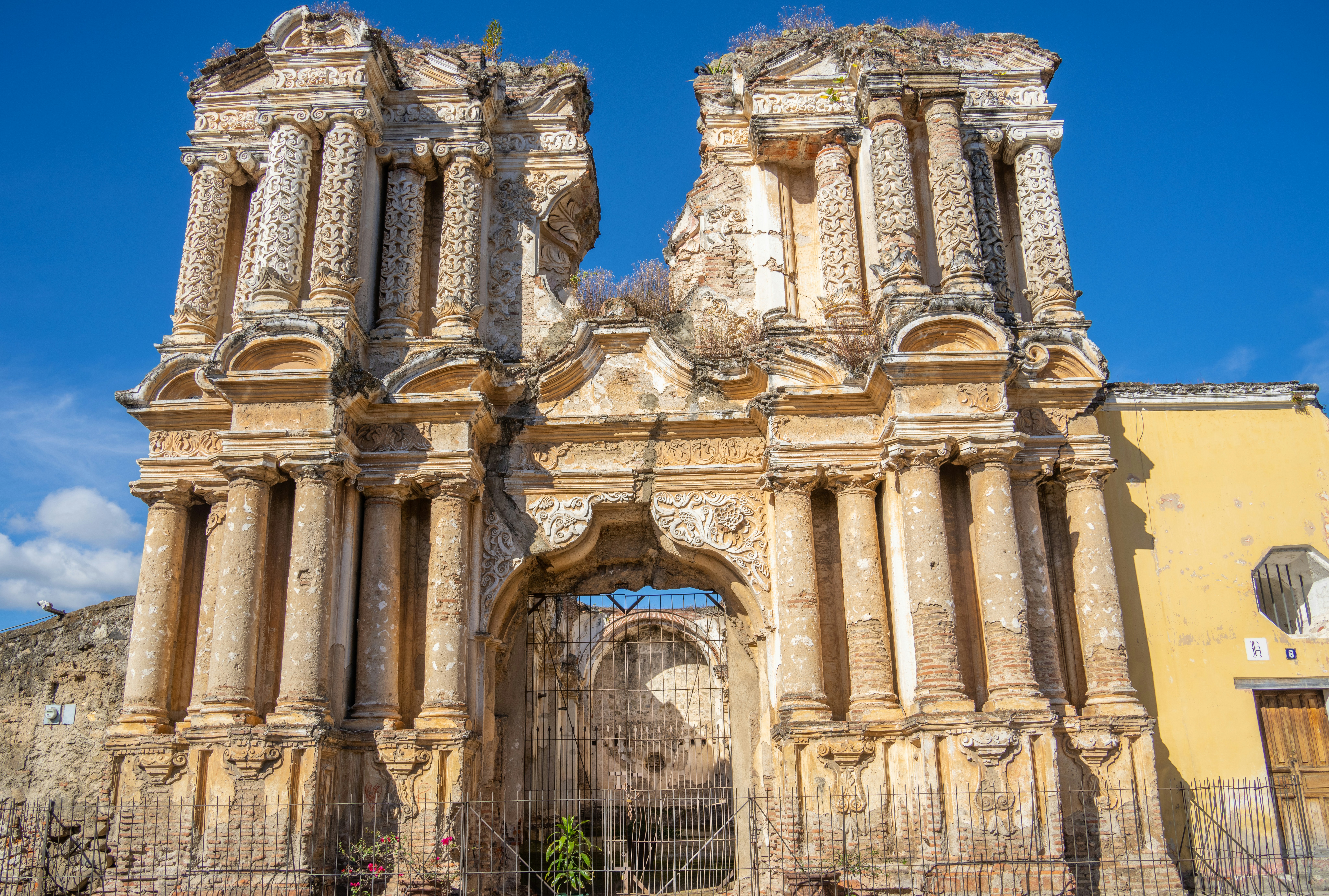 Ornate stone ruins of an ancient building under a clear blue sky.