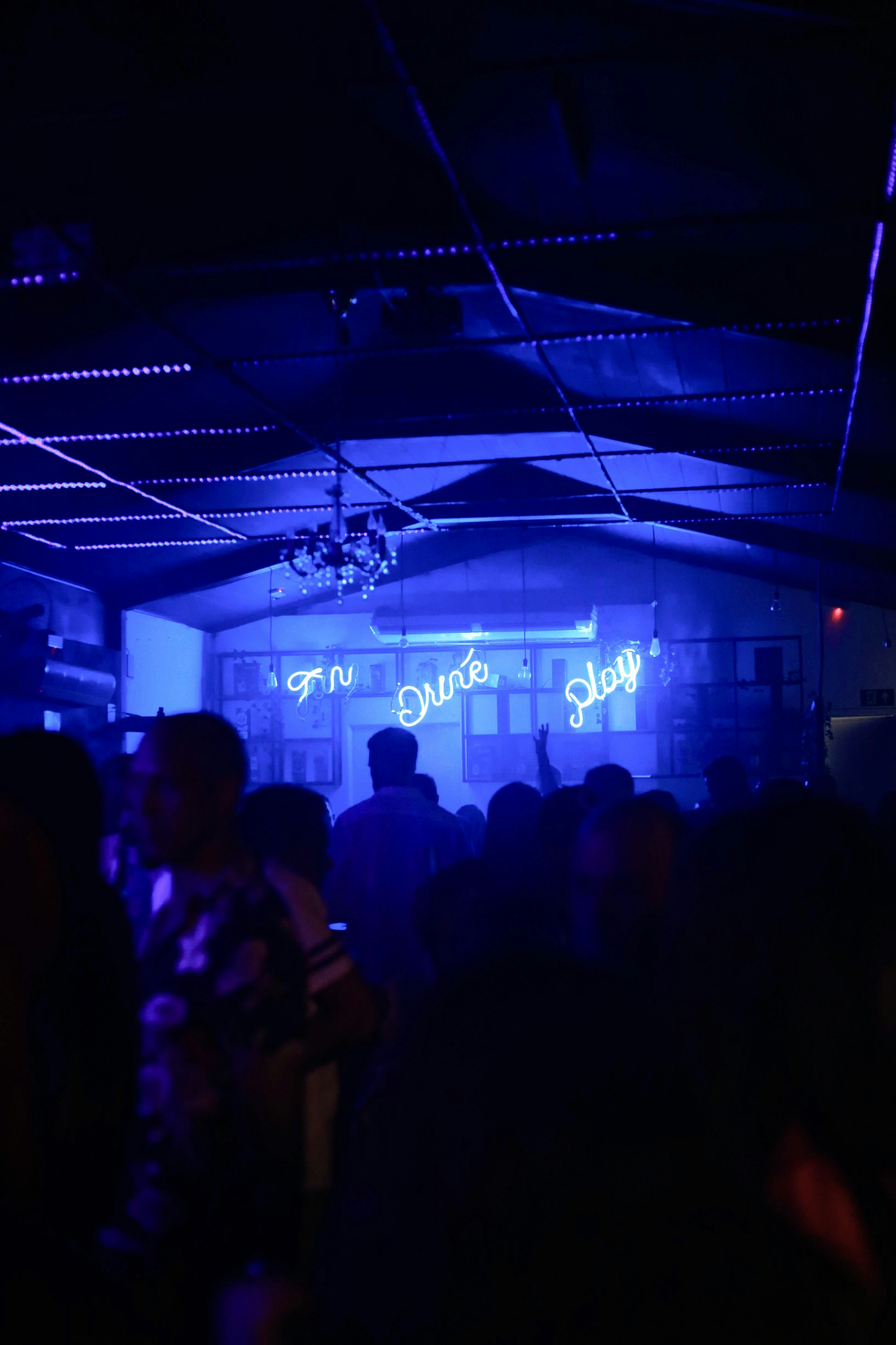 Sapphire Neon Pulse Over a Packed Nightclub