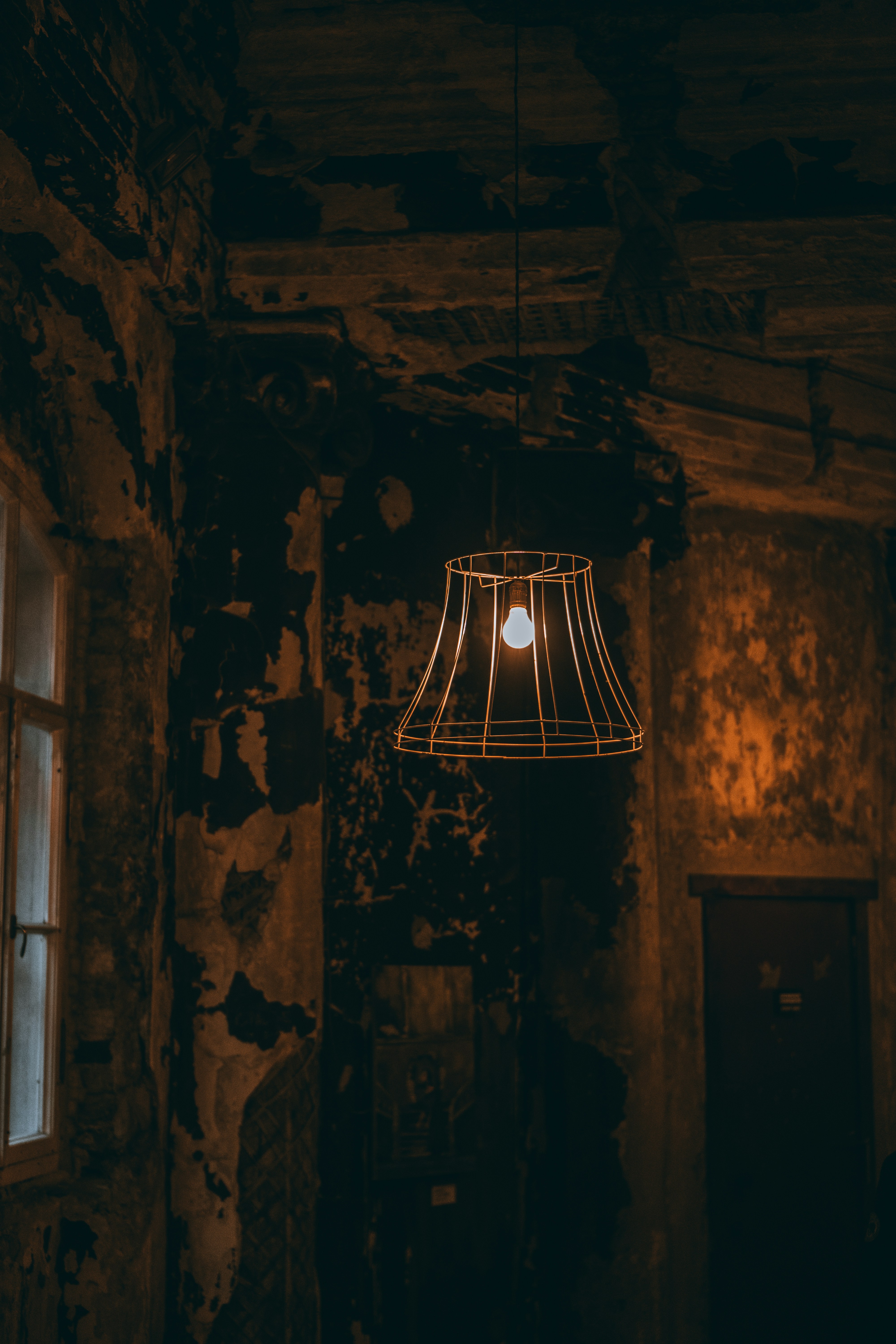 Warm Glow Through a Wire Lampshade in a Crumbling Room