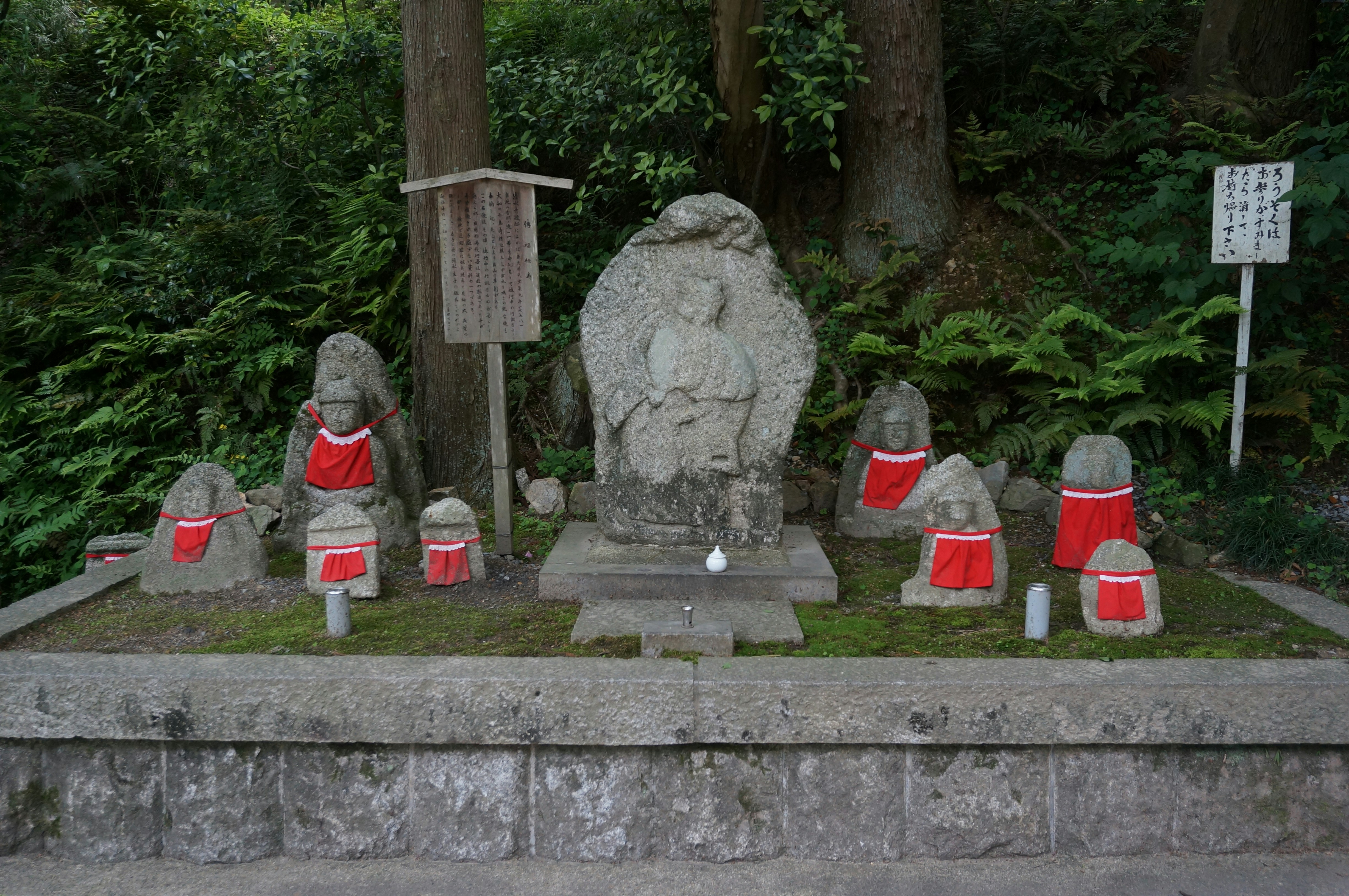 A group of statues sitting on top of a cement slab photo – Free Art ...