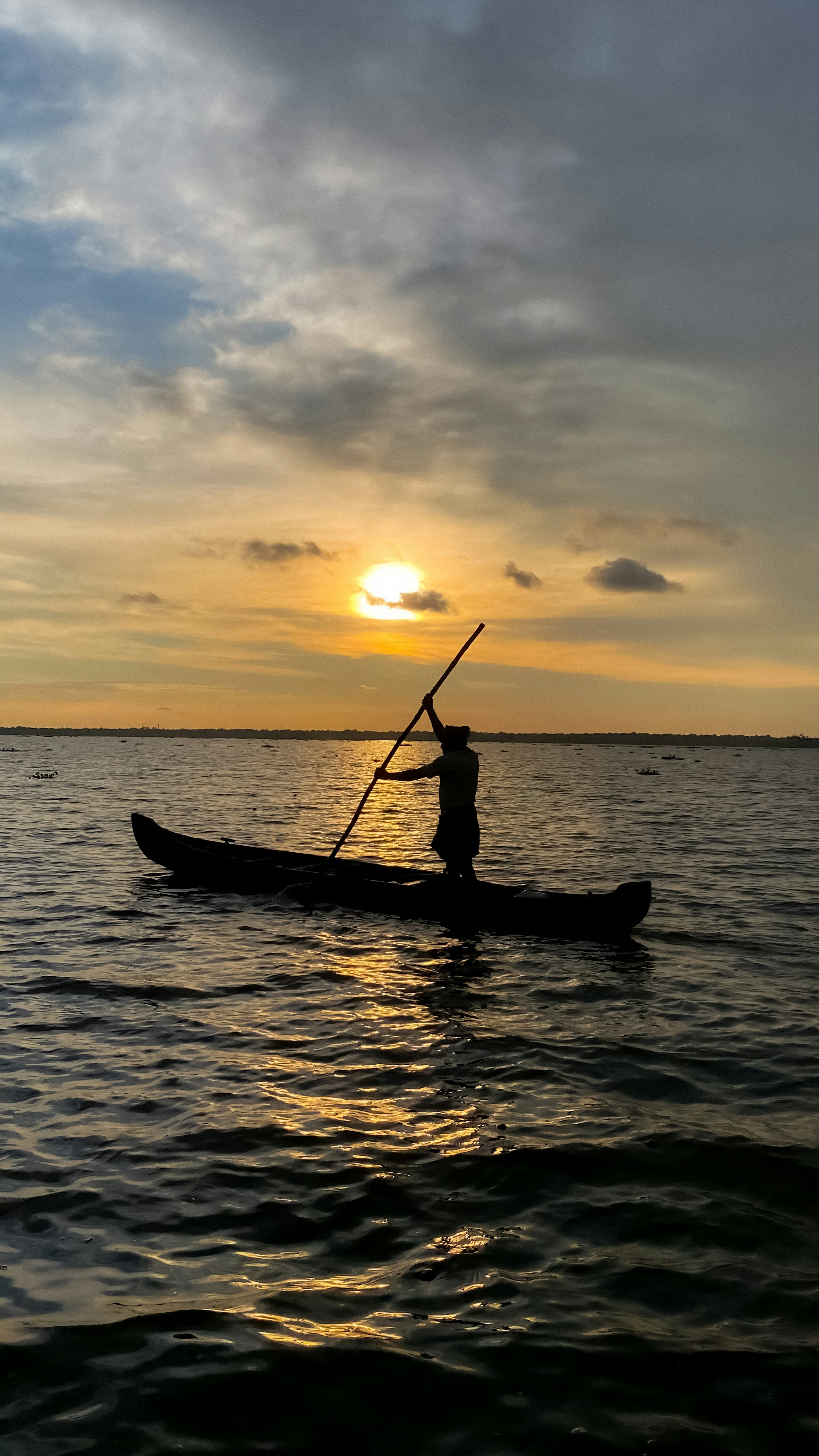 A person in a boat on a body of water photo – Free Human Image on Unsplash