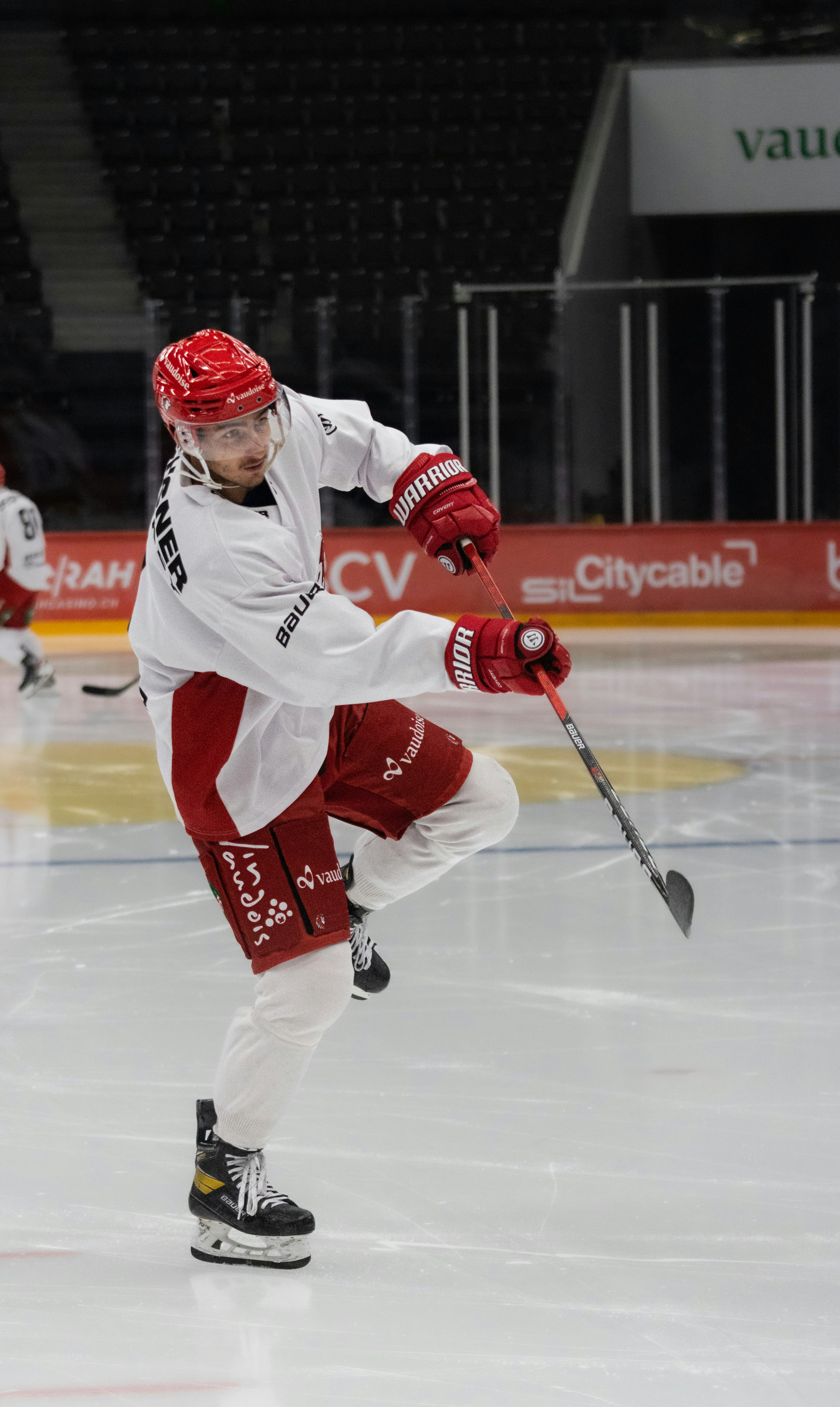 A man in a red and white uniform skating on an ice rink photo – Free ...