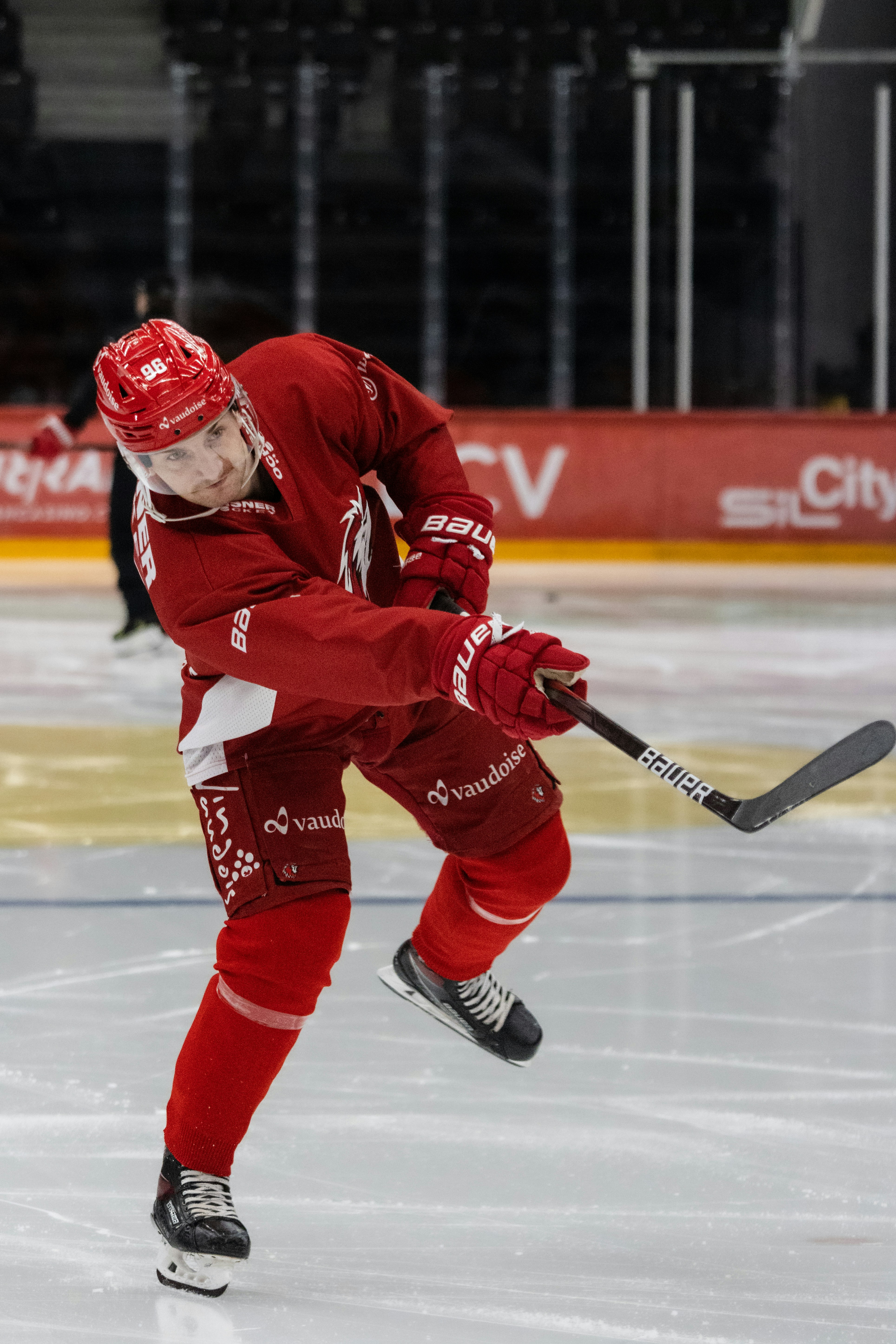 A man in a red uniform skating on an ice rink photo – Free Lausanne ...