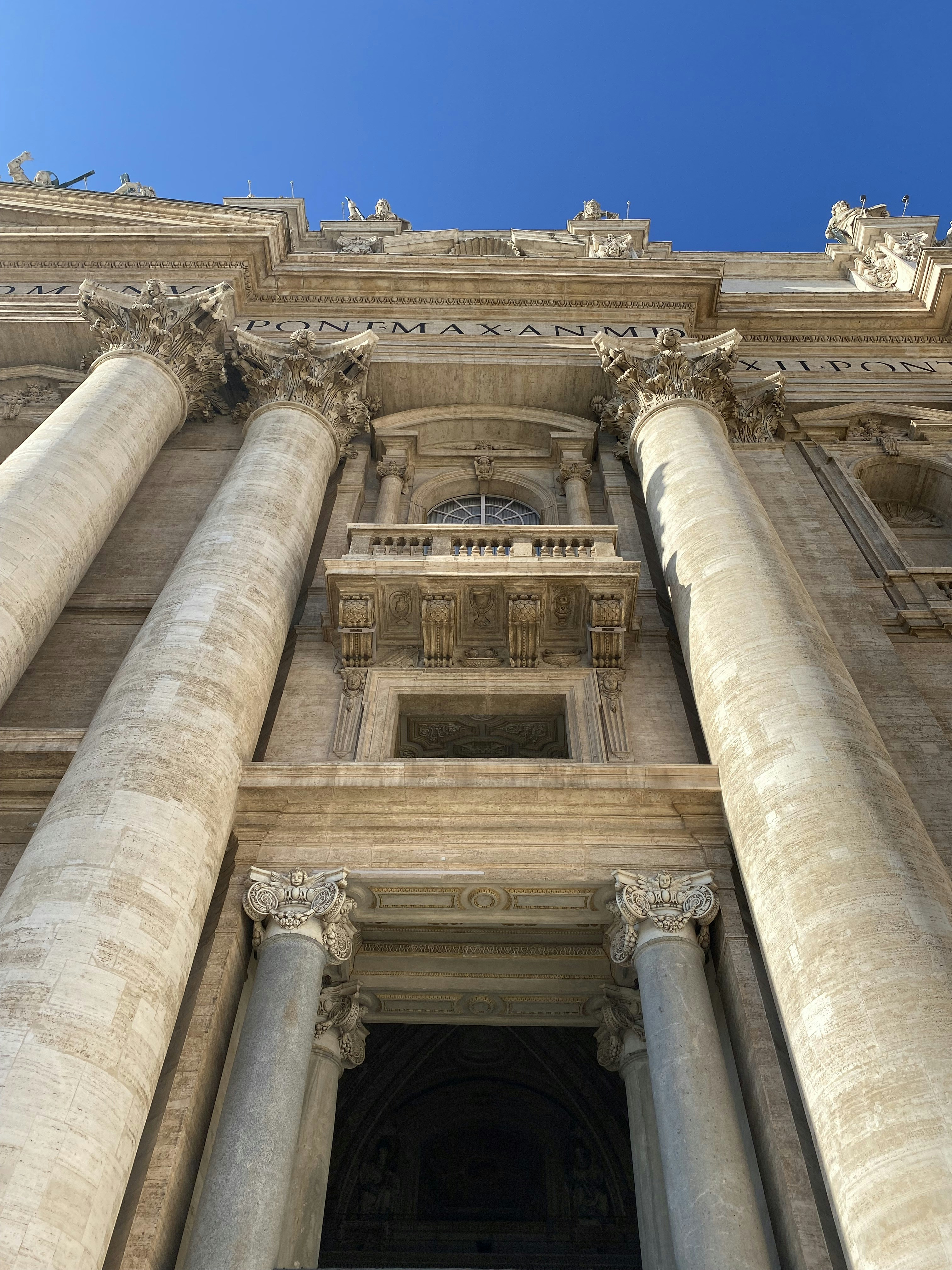 A tall building with columns and a clock photo – Free St. peter's ...