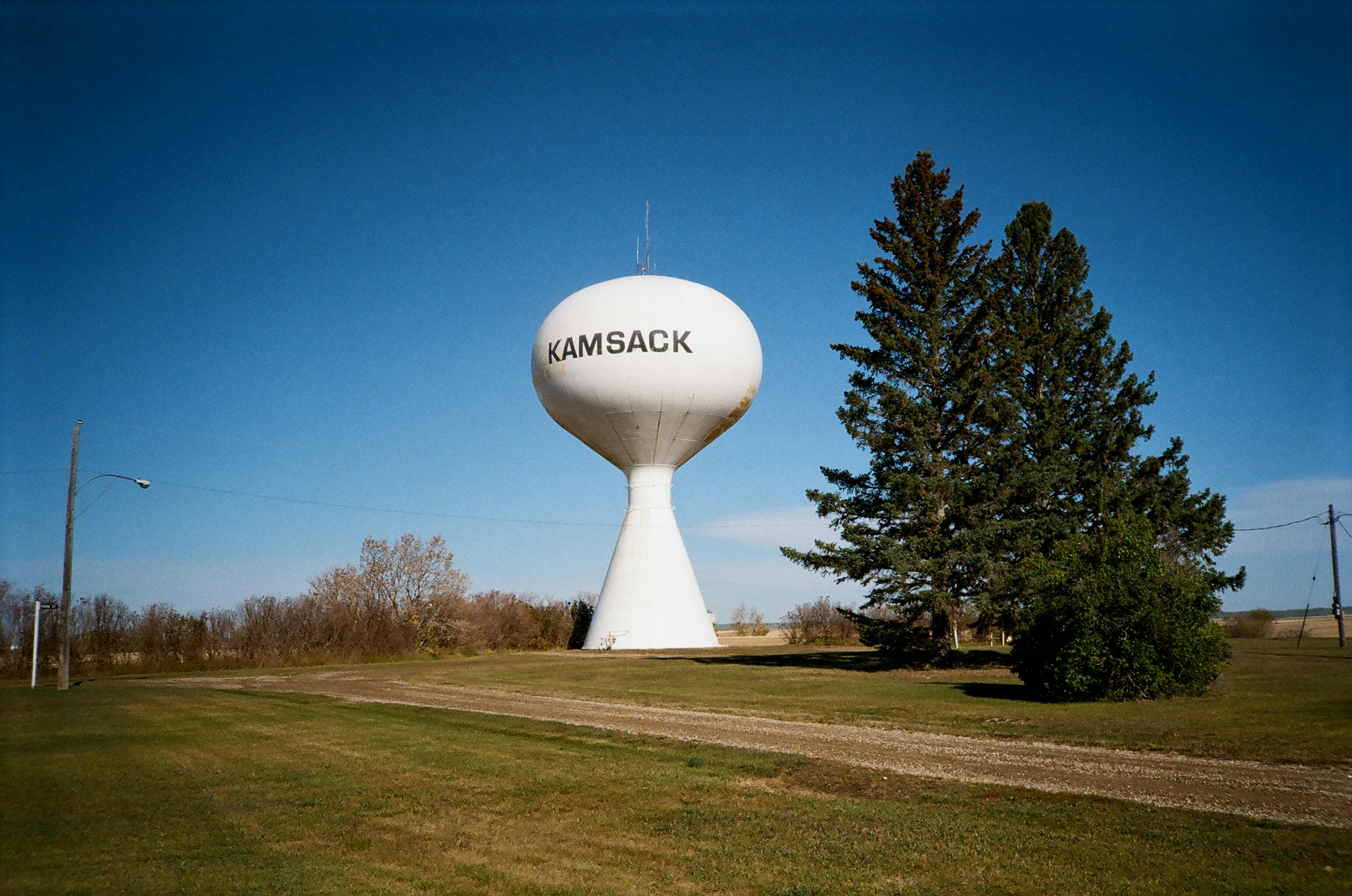A large white water tower sitting in the middle of a field photo – Free ...