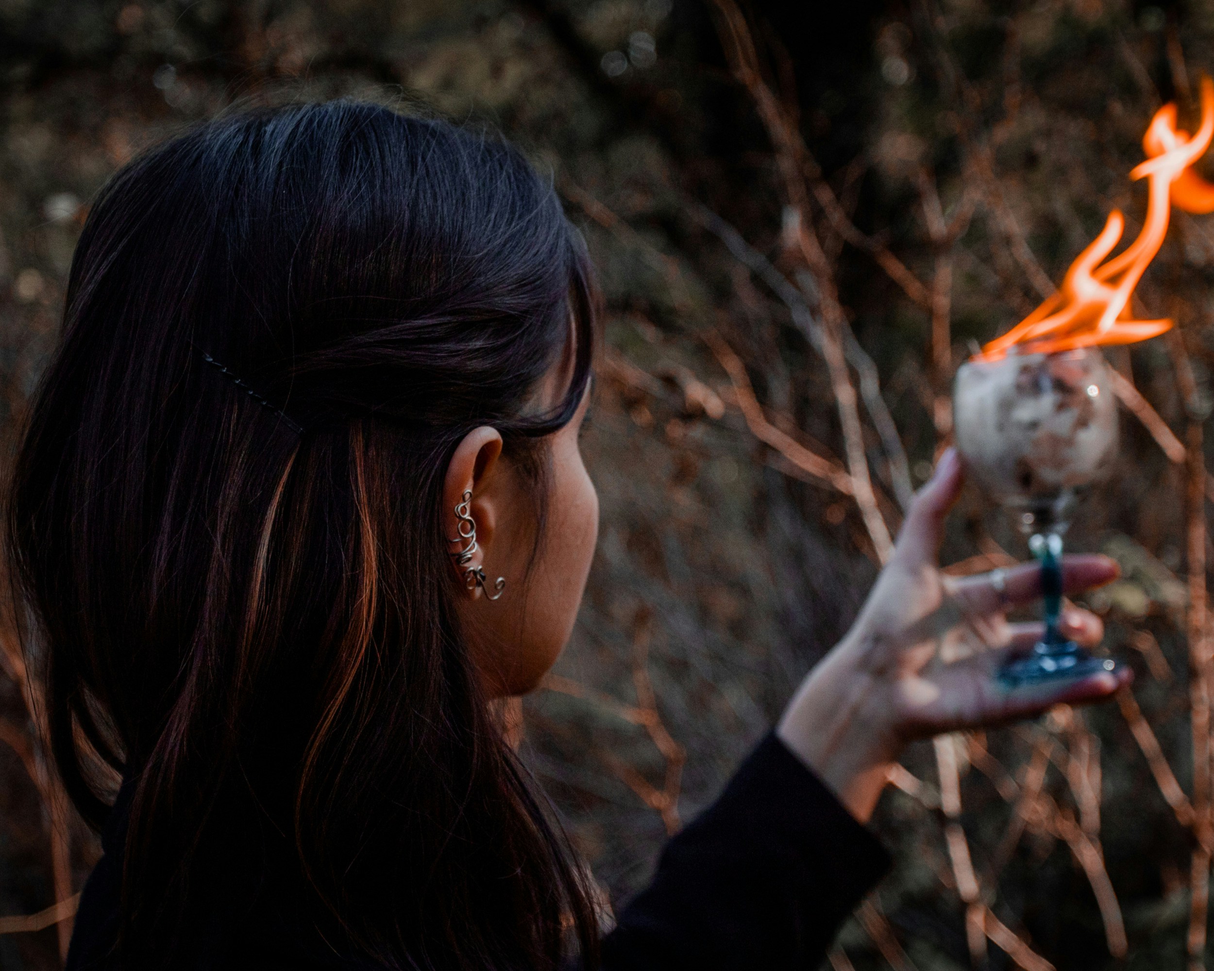 Ember in Hand, Firelit Portrait Under Quiet Pines