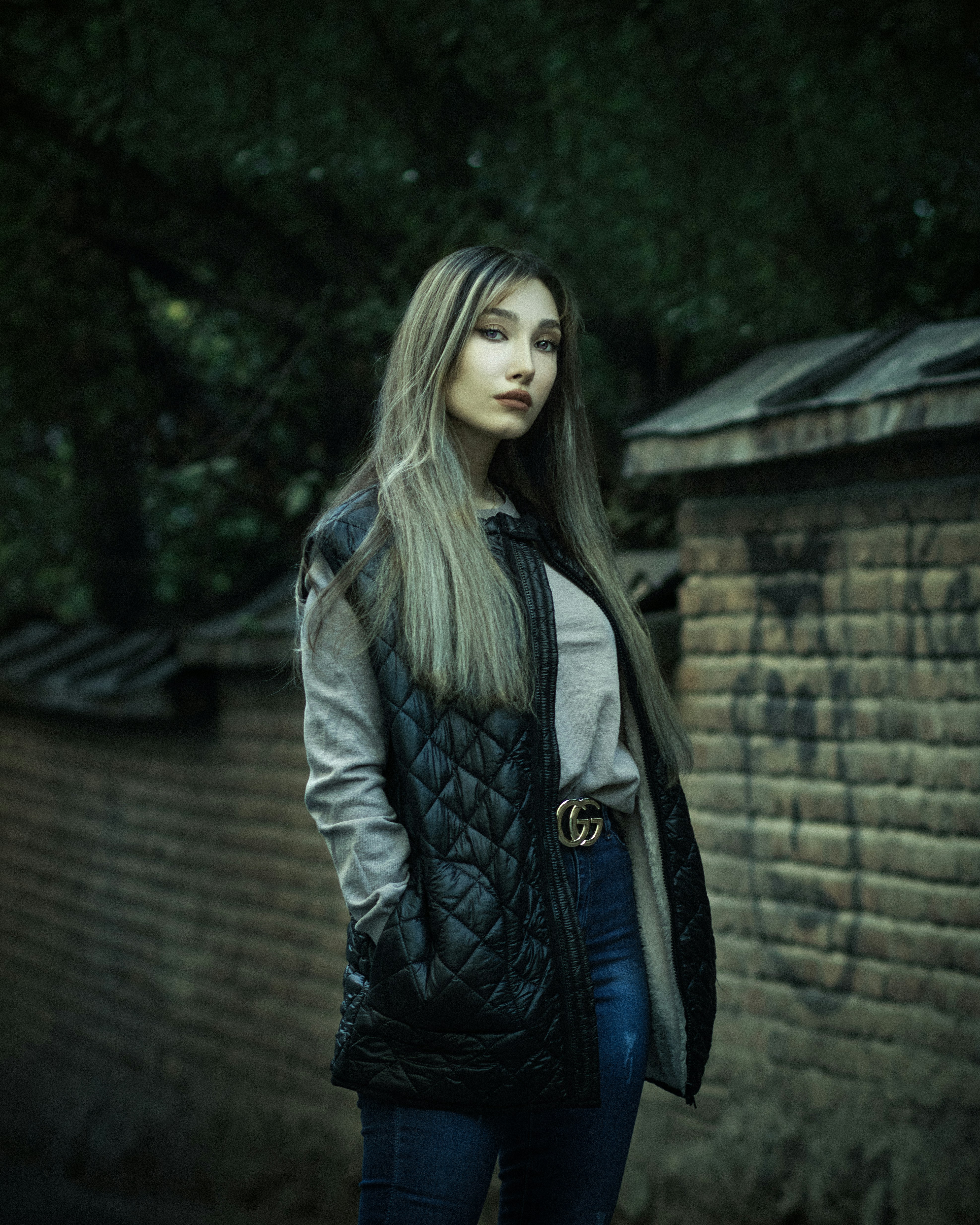 Quiet poise by the brick wall: a cool-toned street-style portrait