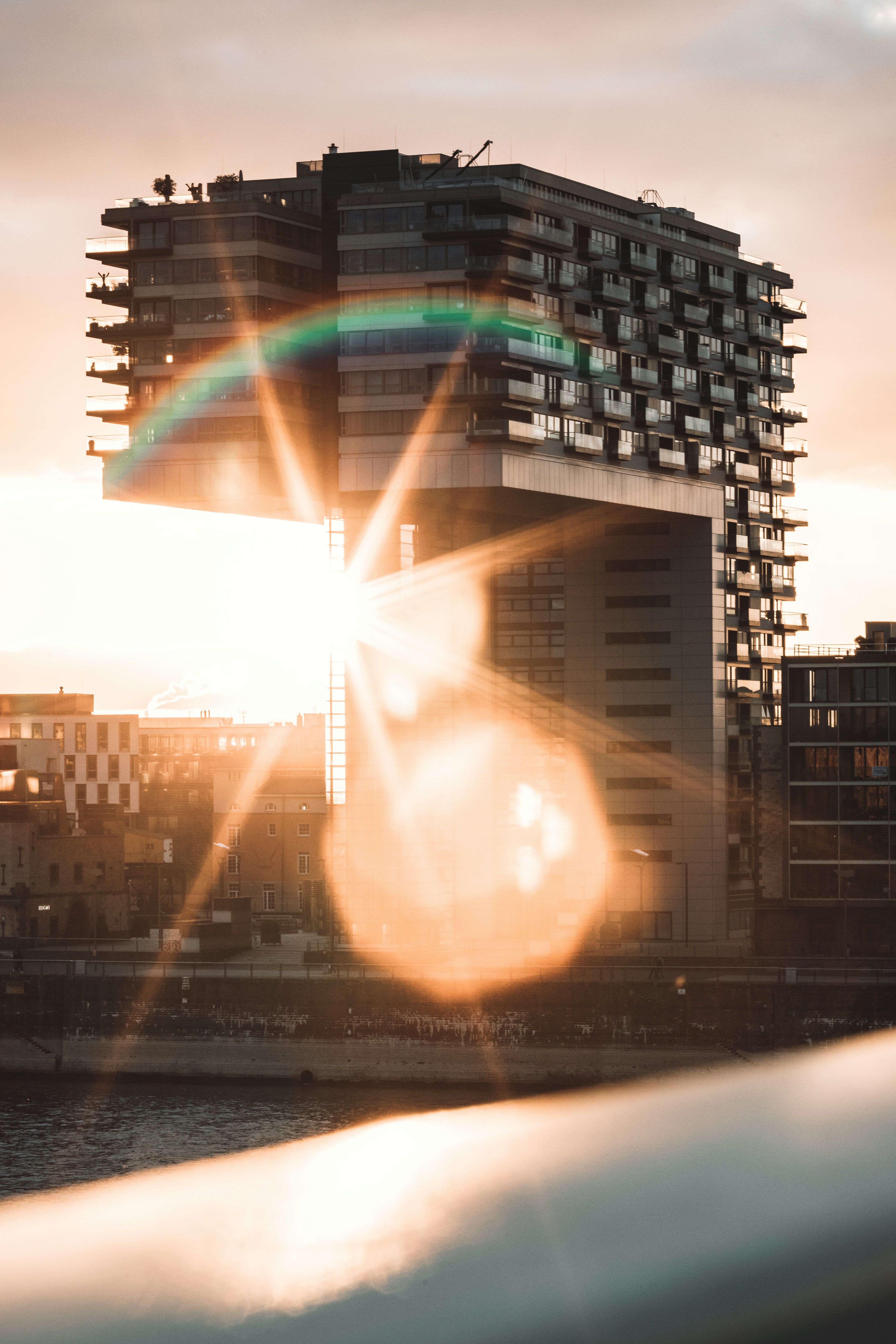 Sunburst Over a Floating Tower: Lens Flare Meets Riverside Skyline