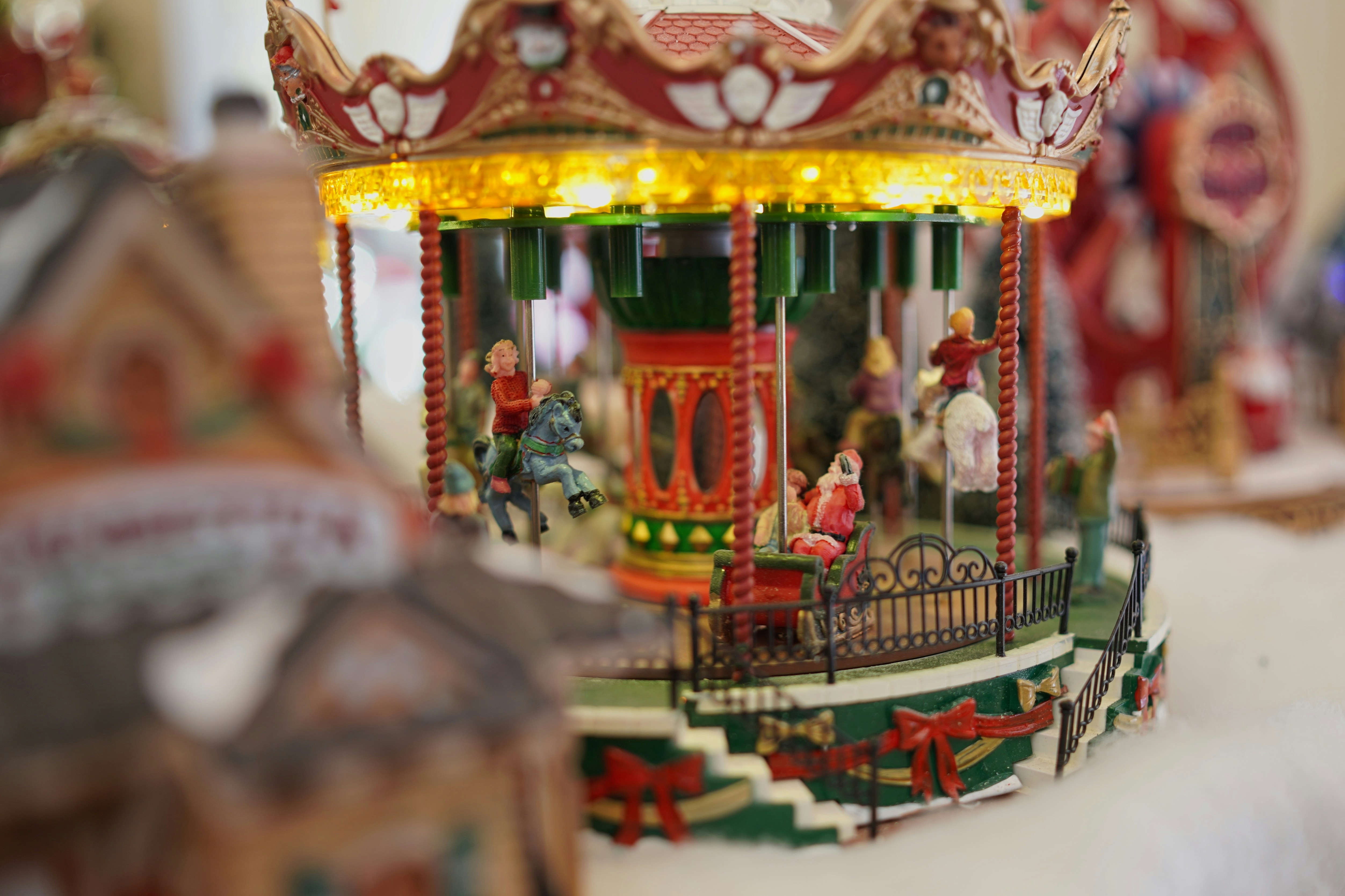 Collectible christmas village in our hotel room in Arezzo, Tuscany. | a merry go round with people on it