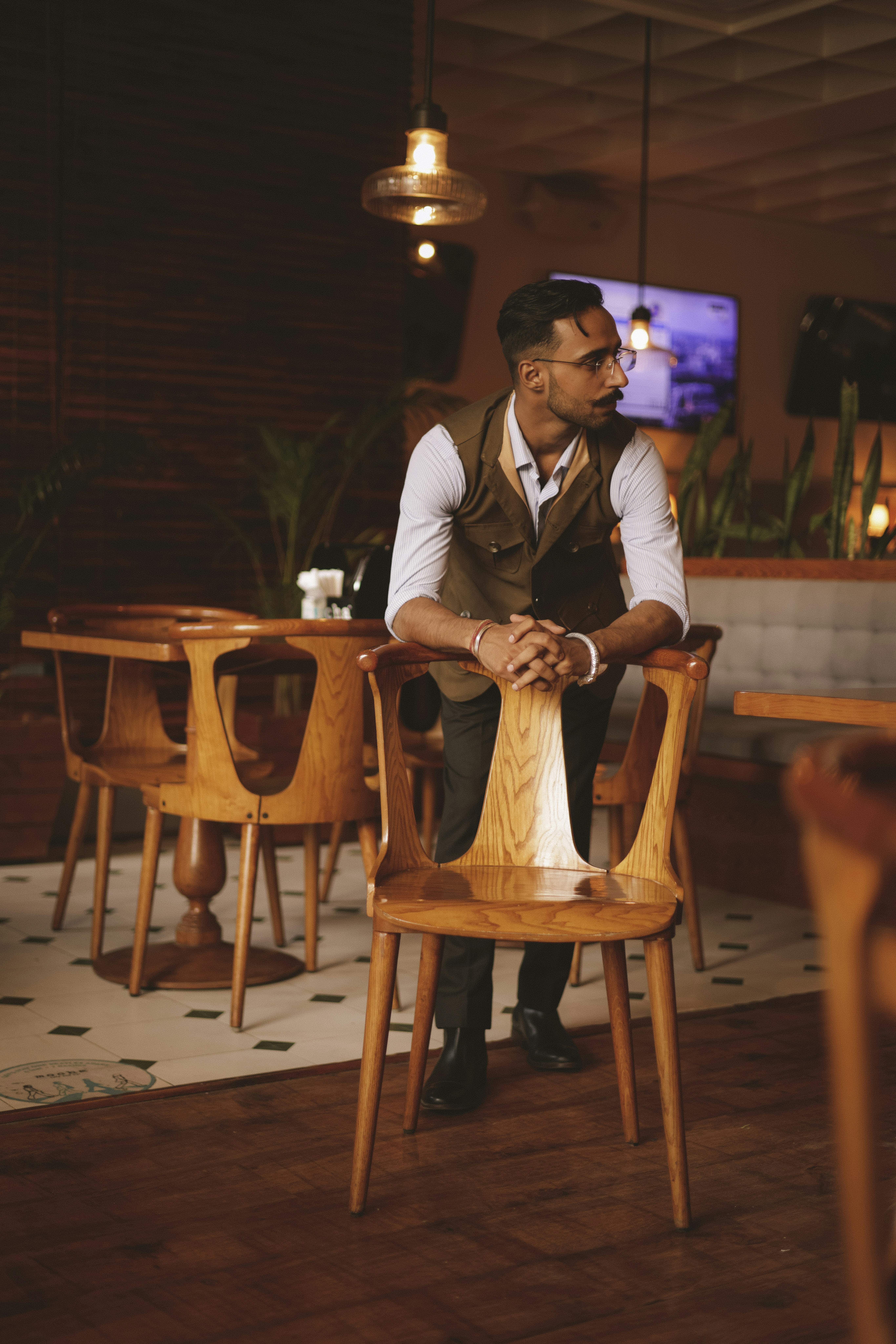 a man sitting at a table with a vase in his hand