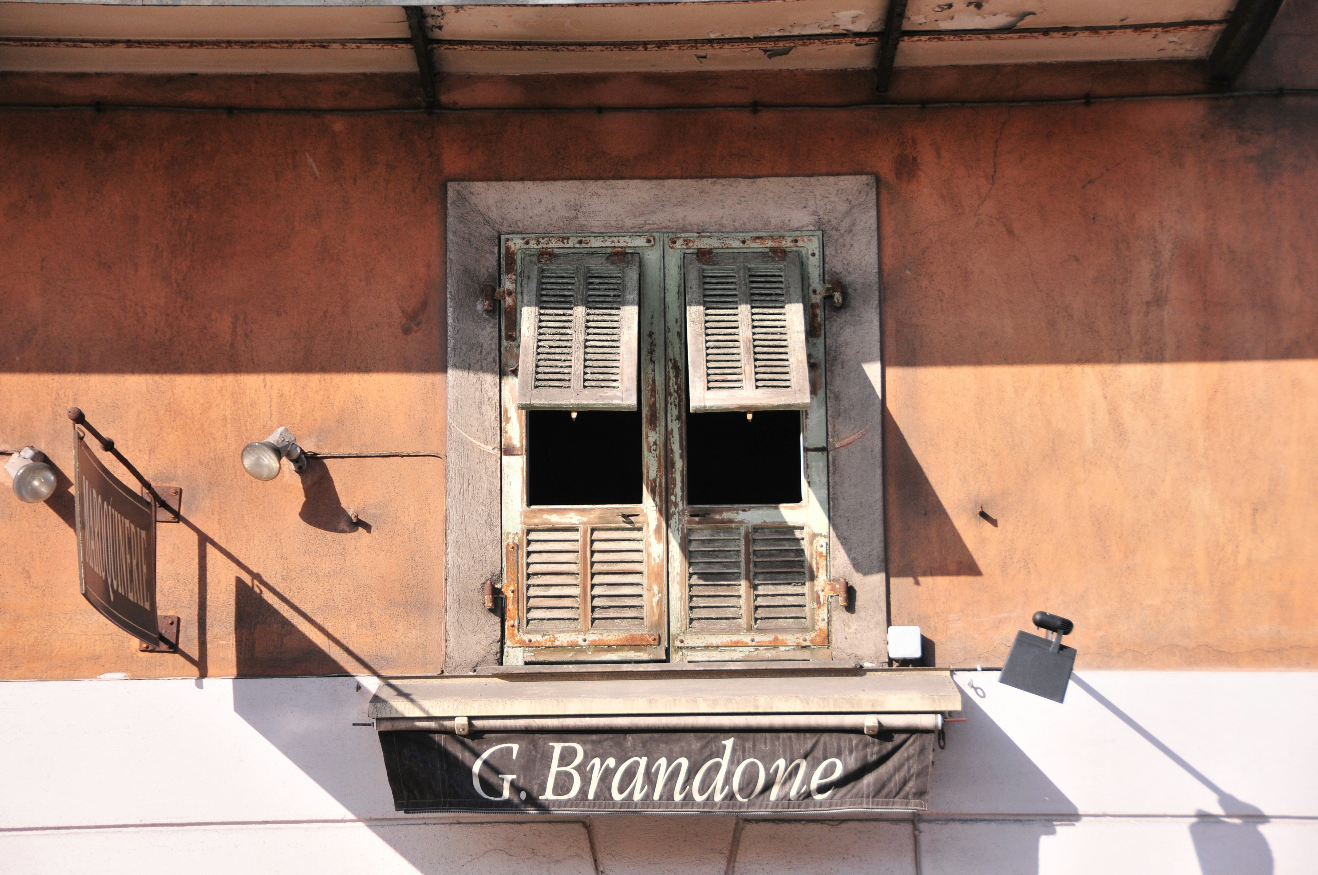 a building with shutters and a sign on the side of it