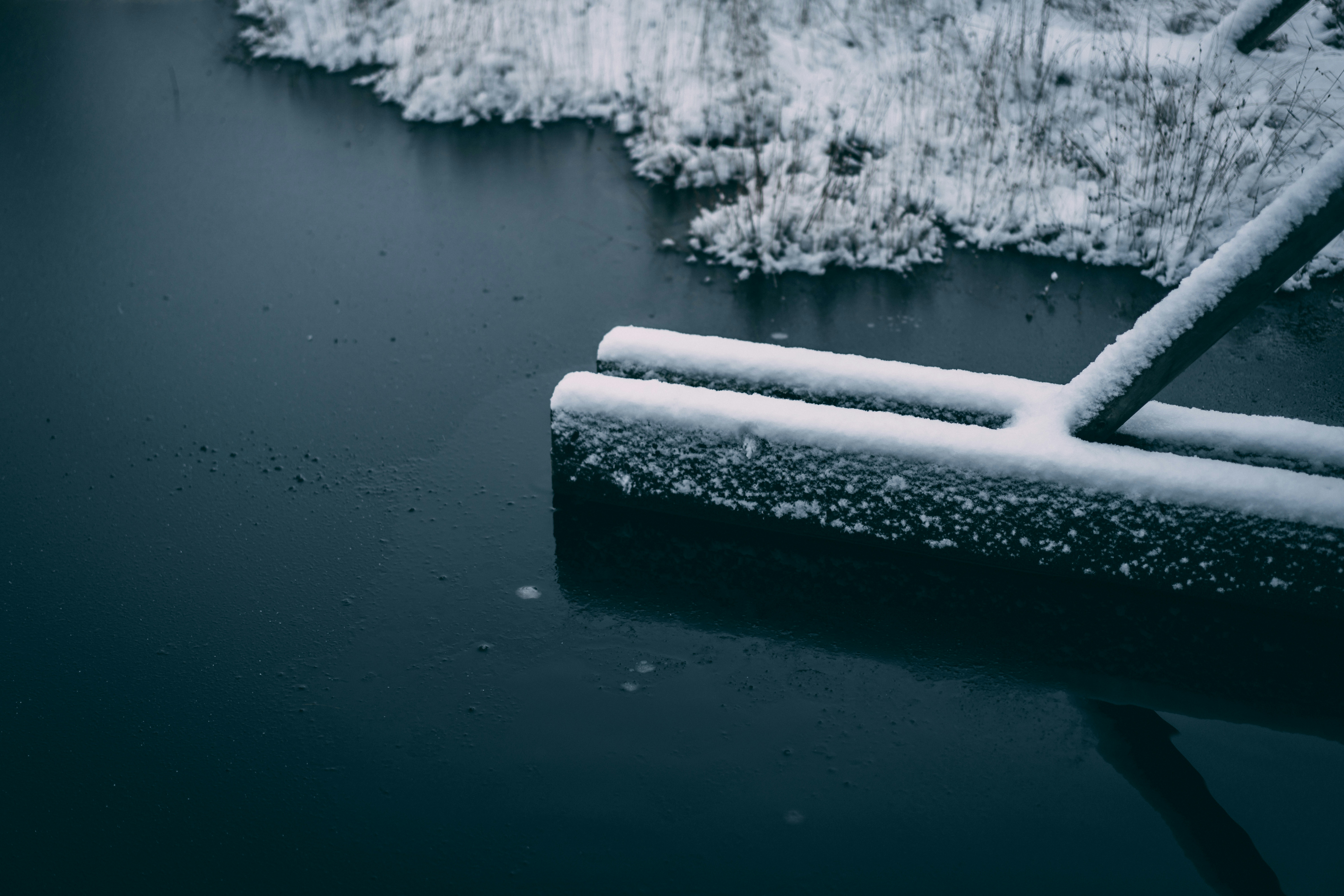 Snow-Capped Rail Barge Drifting over Quiet Frozen Water