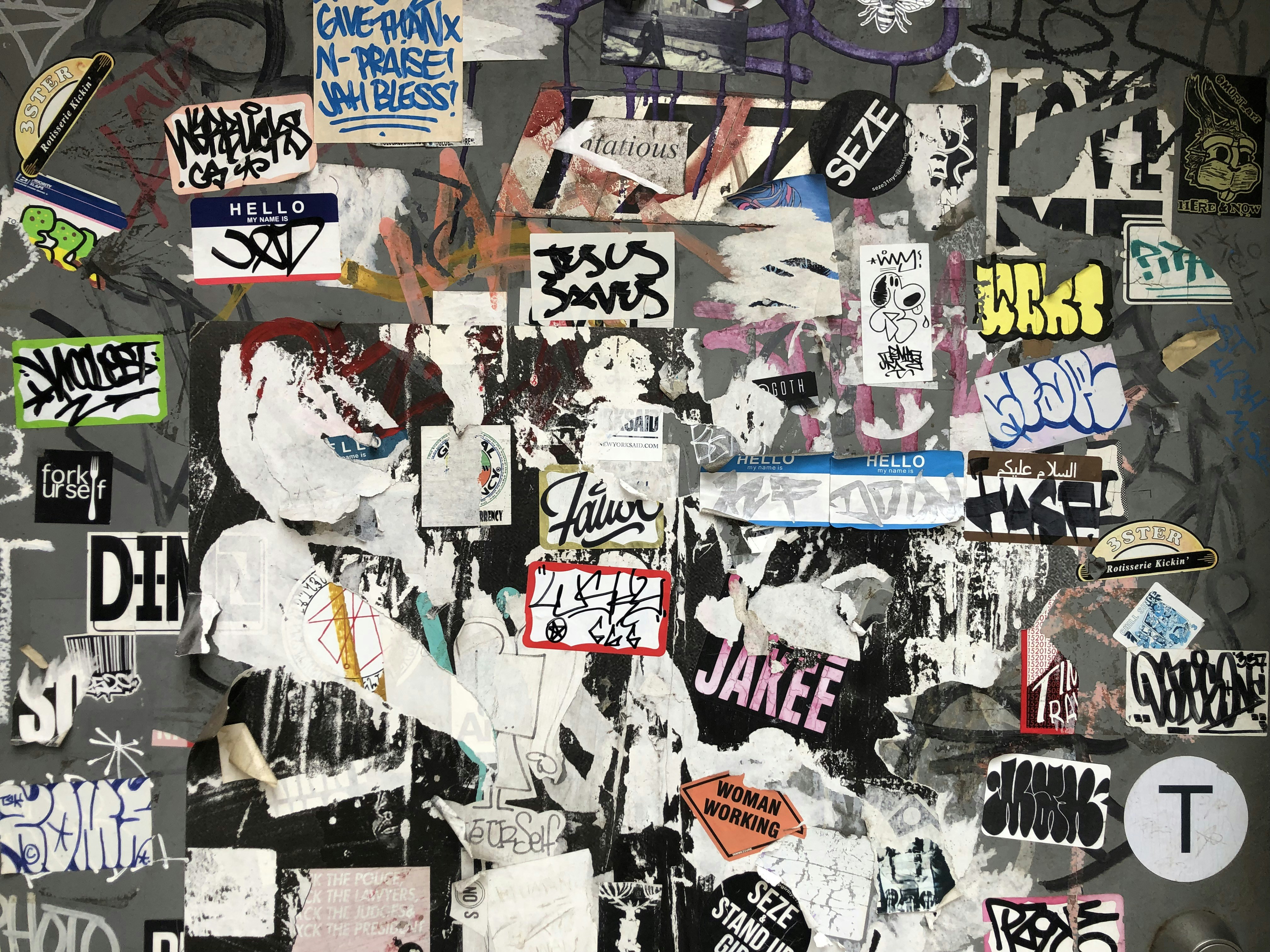 A wall covered in lots of different types of stickers photo – Free ...