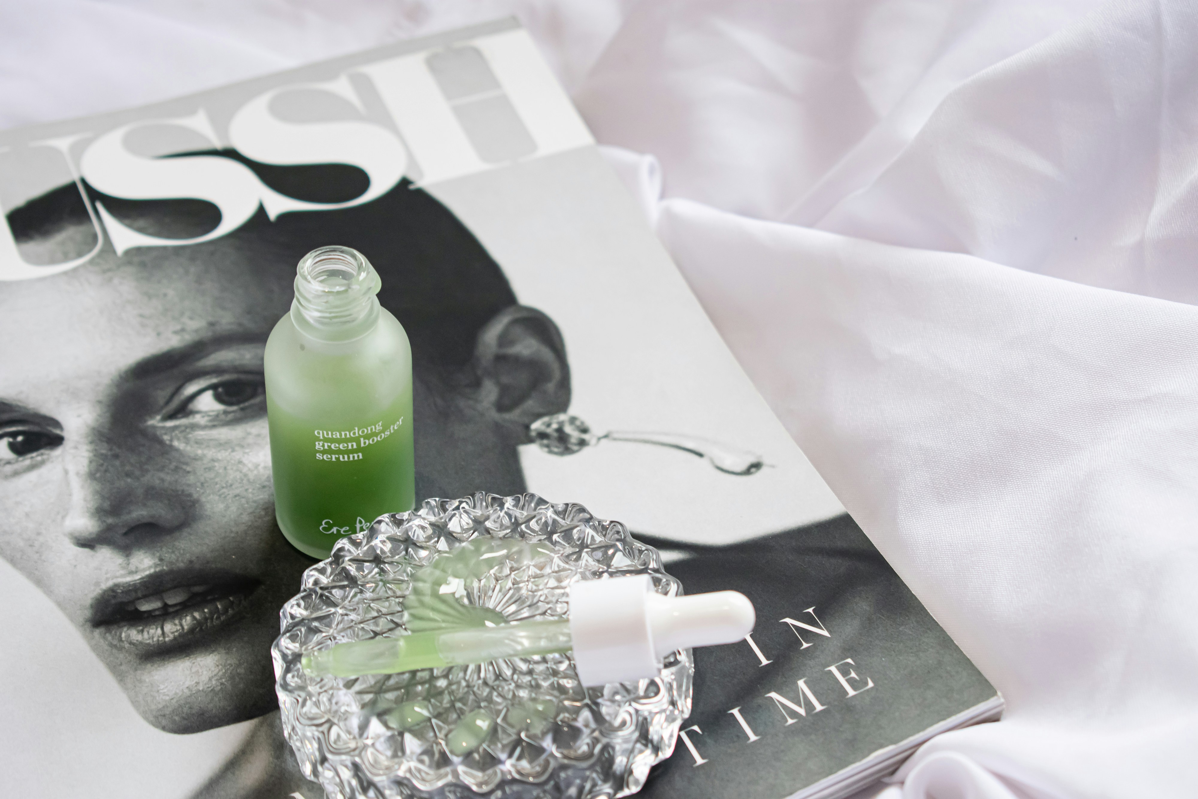 A magazine with a bottle of green liquid next to it photo – Free ...