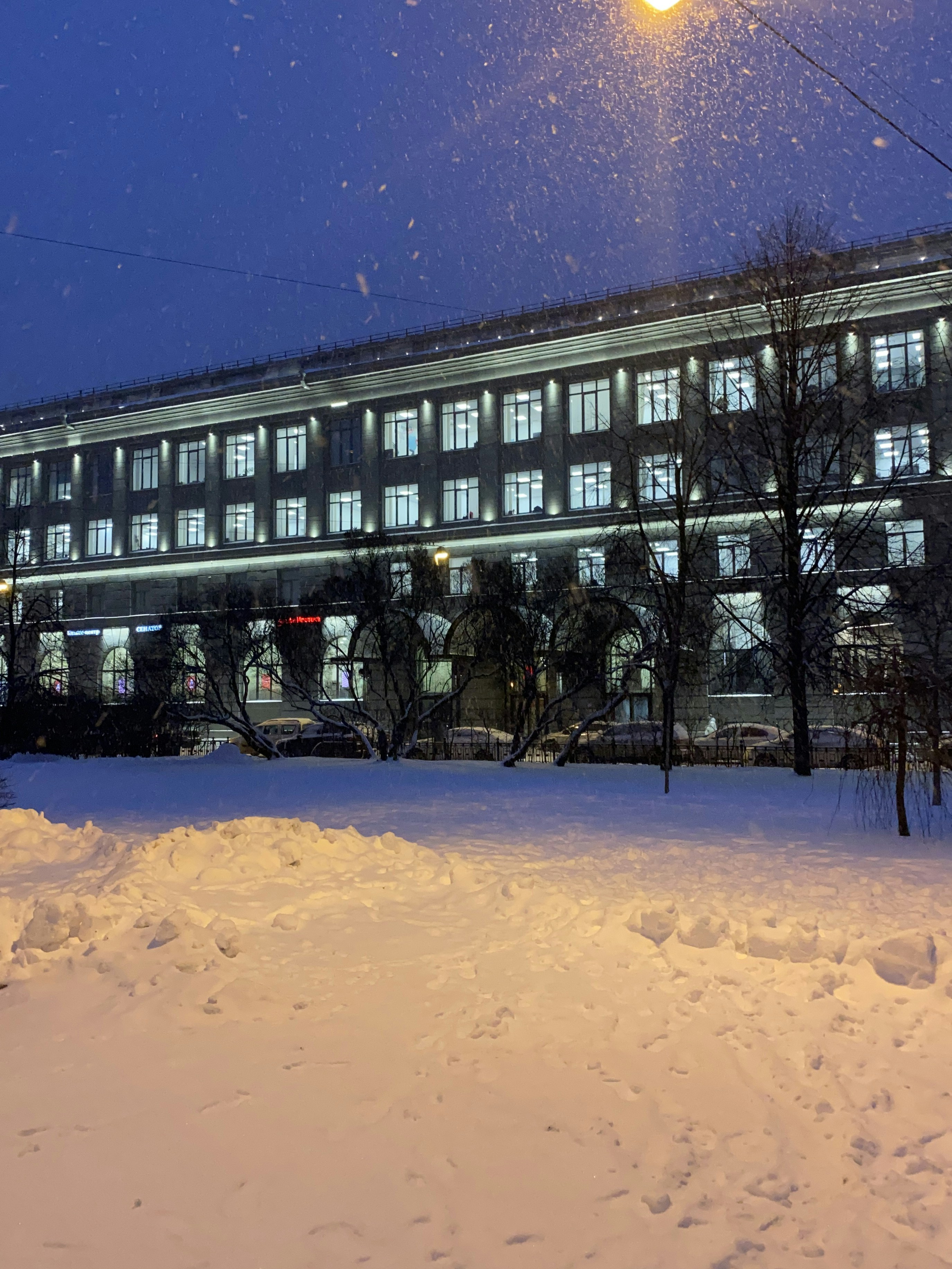 Un bâtiment est éclairé la nuit dans la neige photo – Photo En plein ...