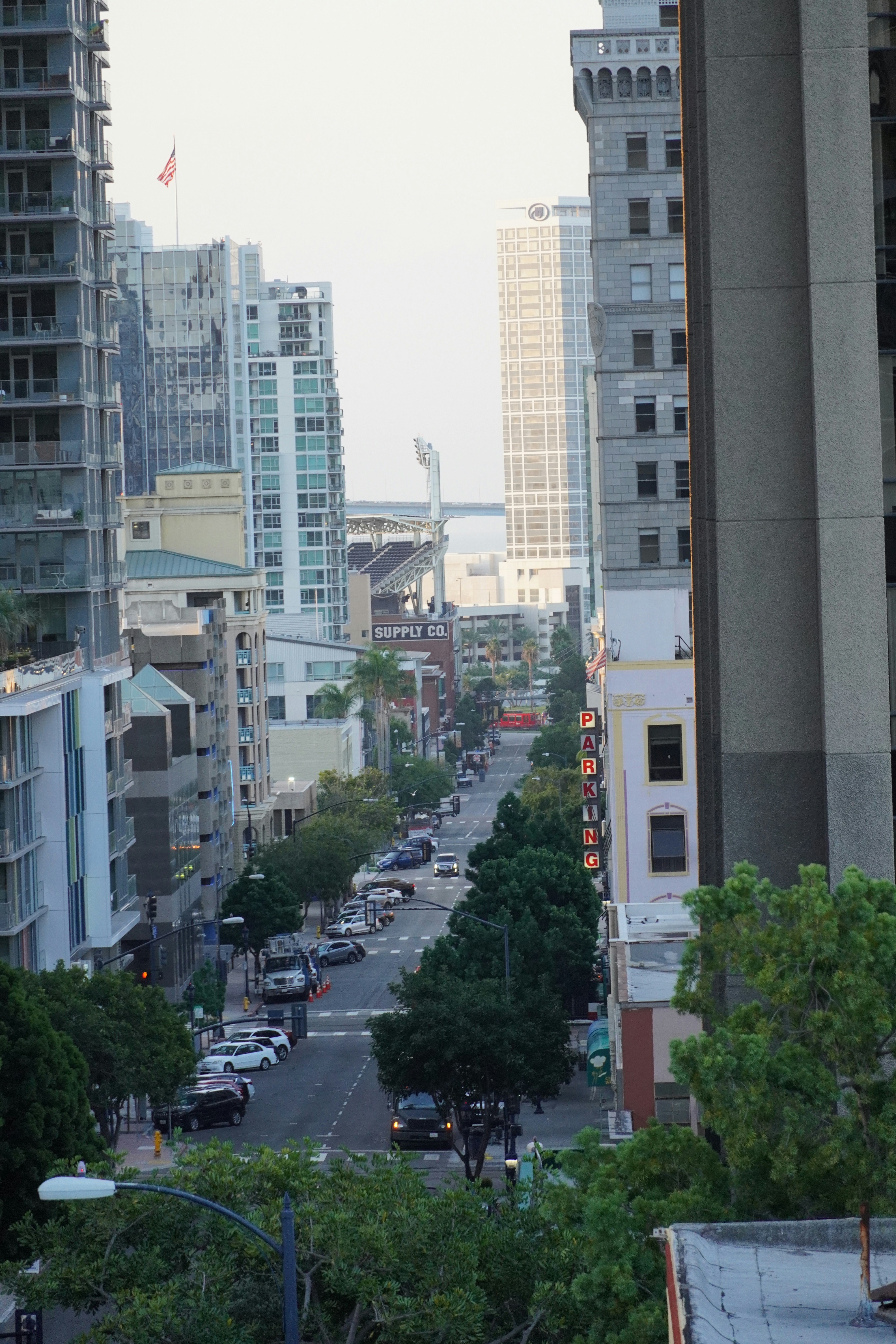 Urban Axis: A Narrow Street Framed by Glass and Shadow Leading Toward the Waterfront