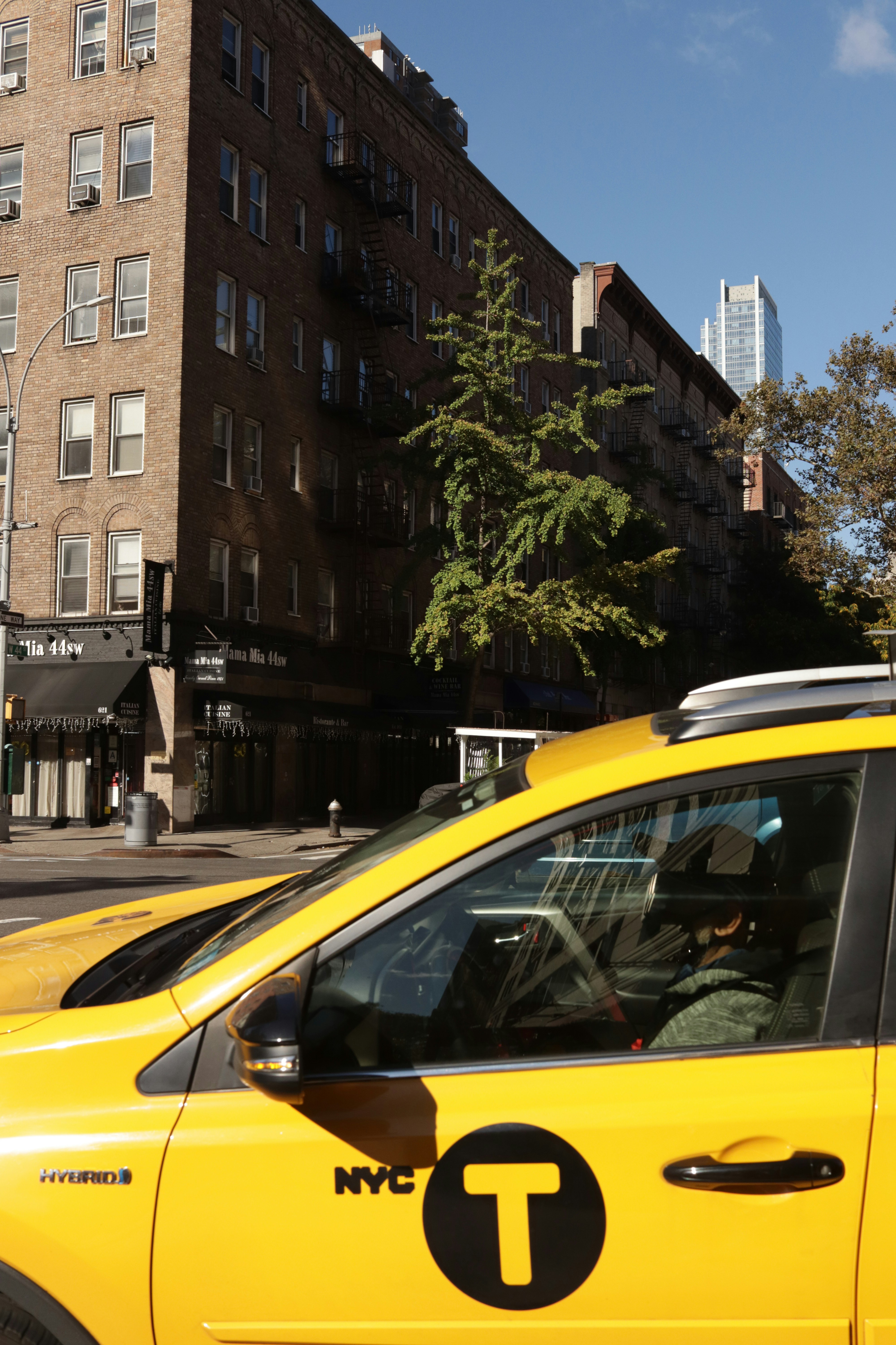 A yellow taxi cab sitting in front of a tall building photo – Free ...