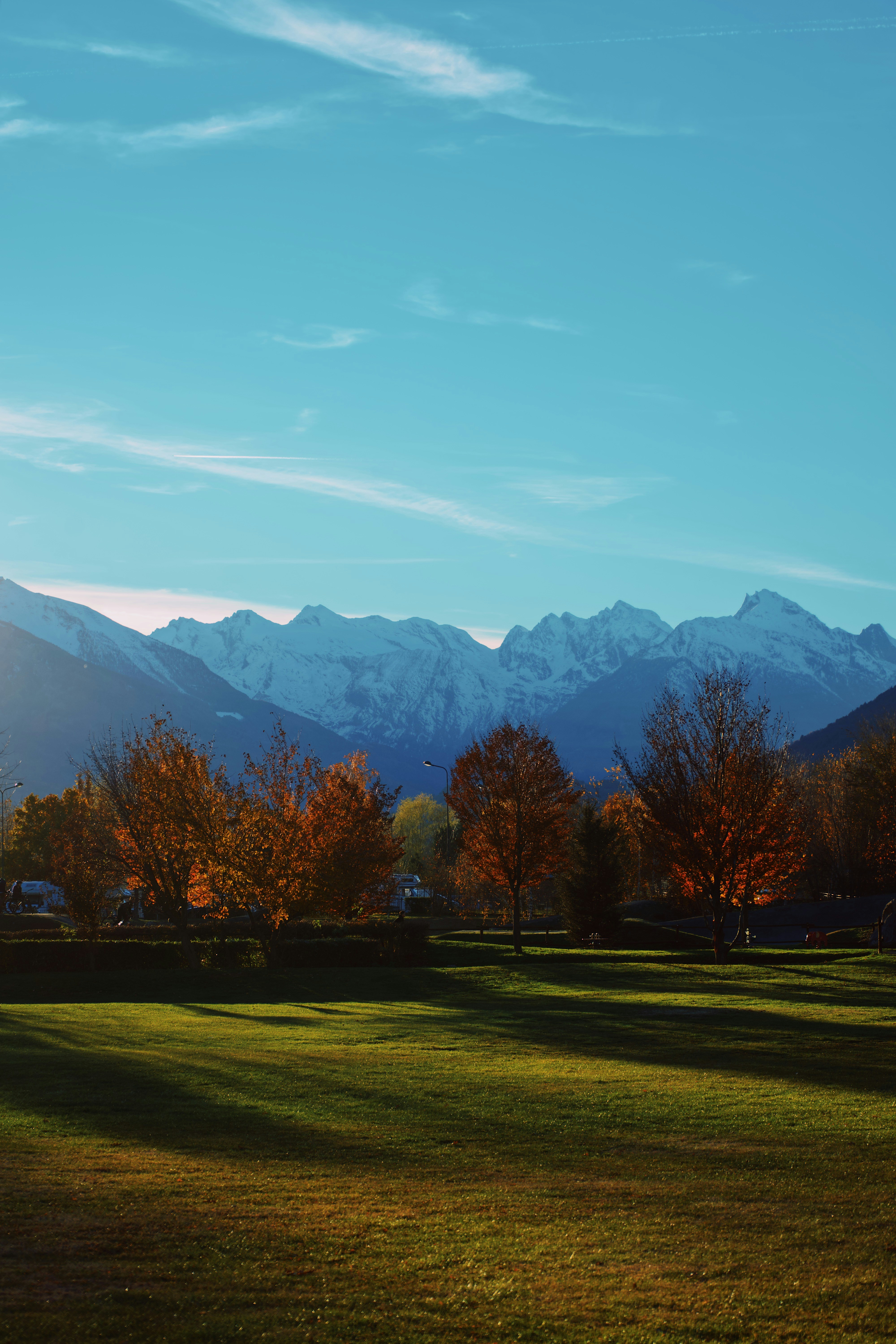 Autumn Edge: A Park Verge Meets Snow-Dusted Alpine Peaks