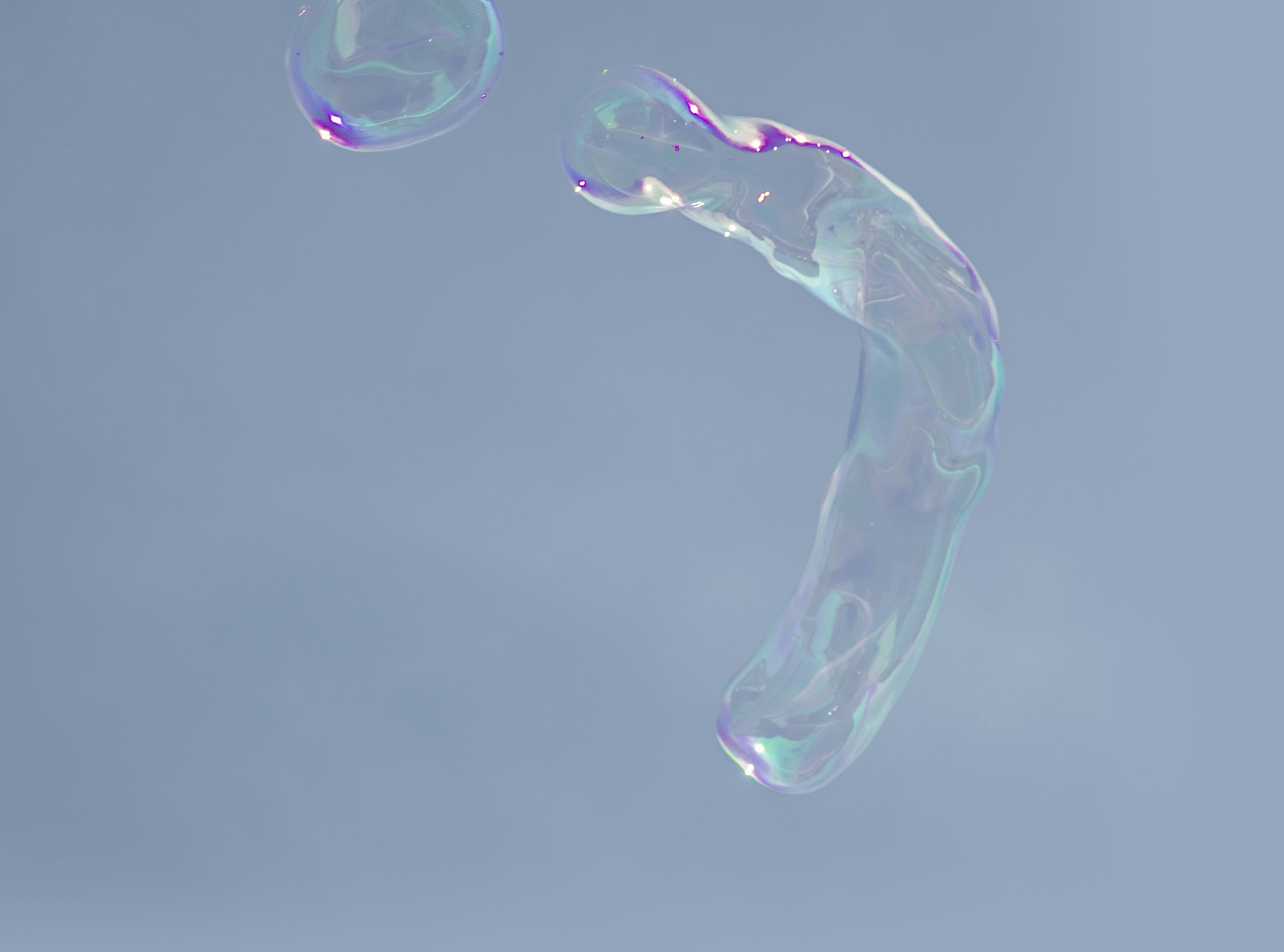 Iridescent Arc in a Sky-Blue Quiet: A Bubble's Dance