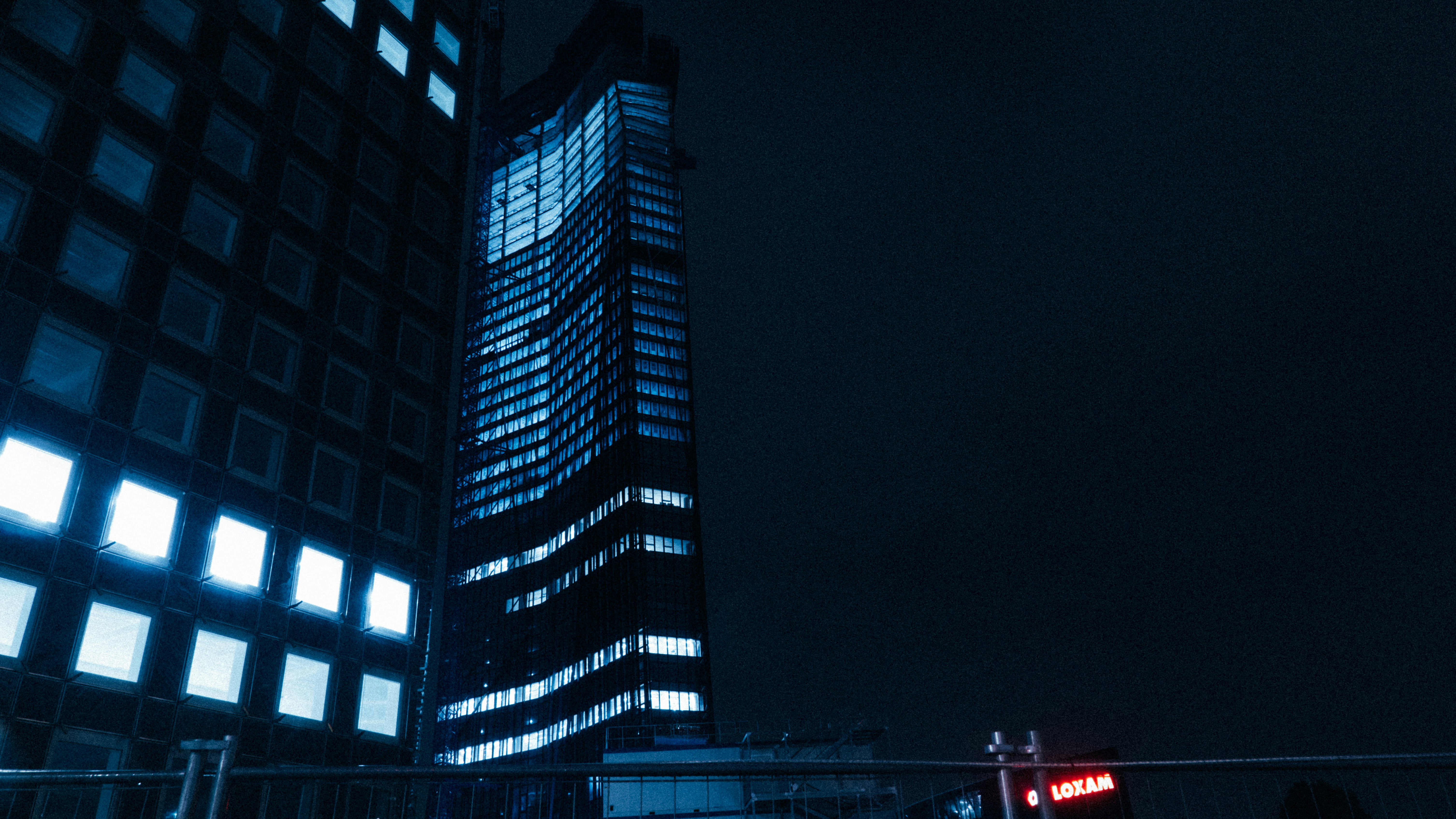 A tall building lit up at night with a traffic light photo – Free Paris ...