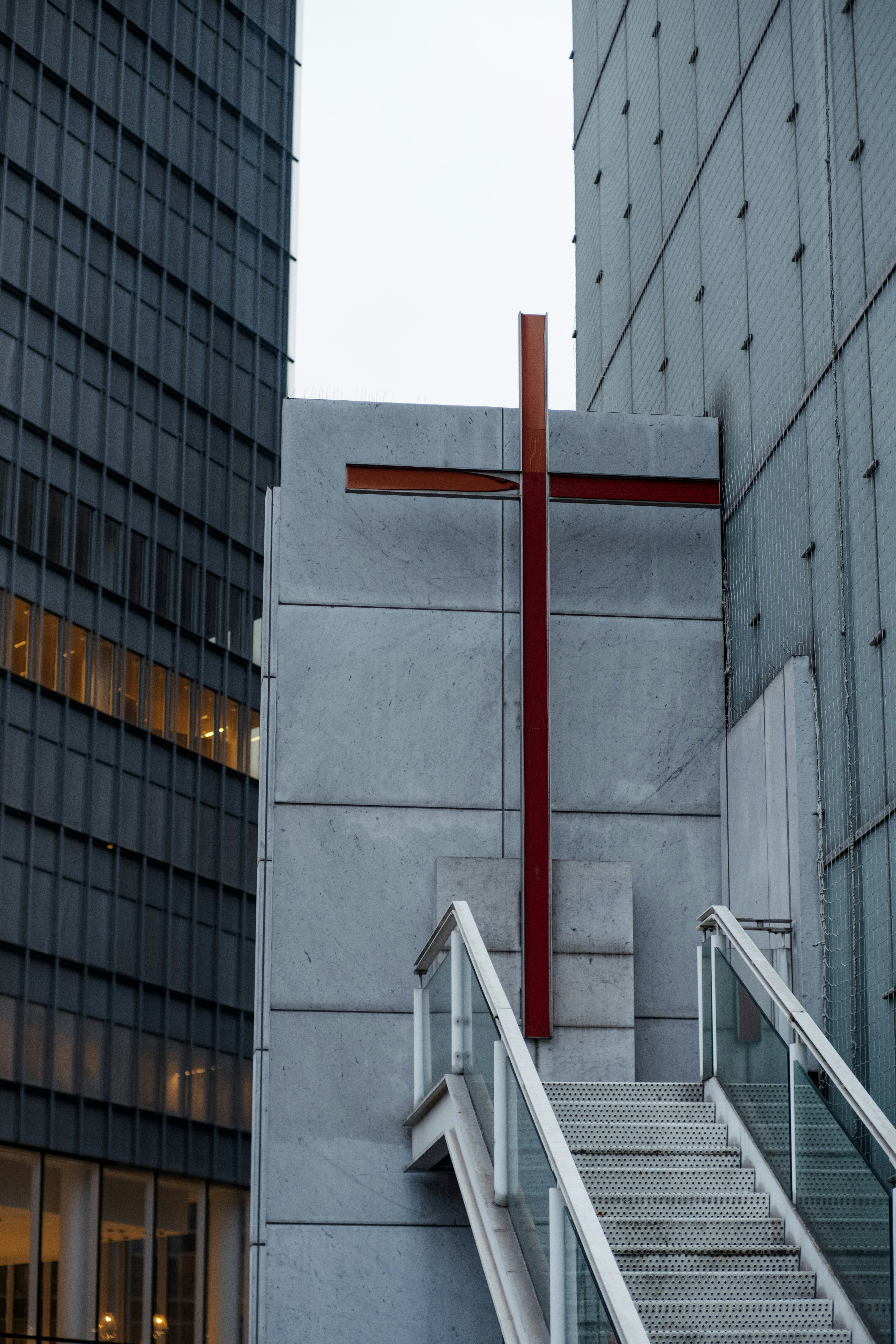 Vertical Crossroads: Concrete Monoliths Framed by Steel and Red Accent