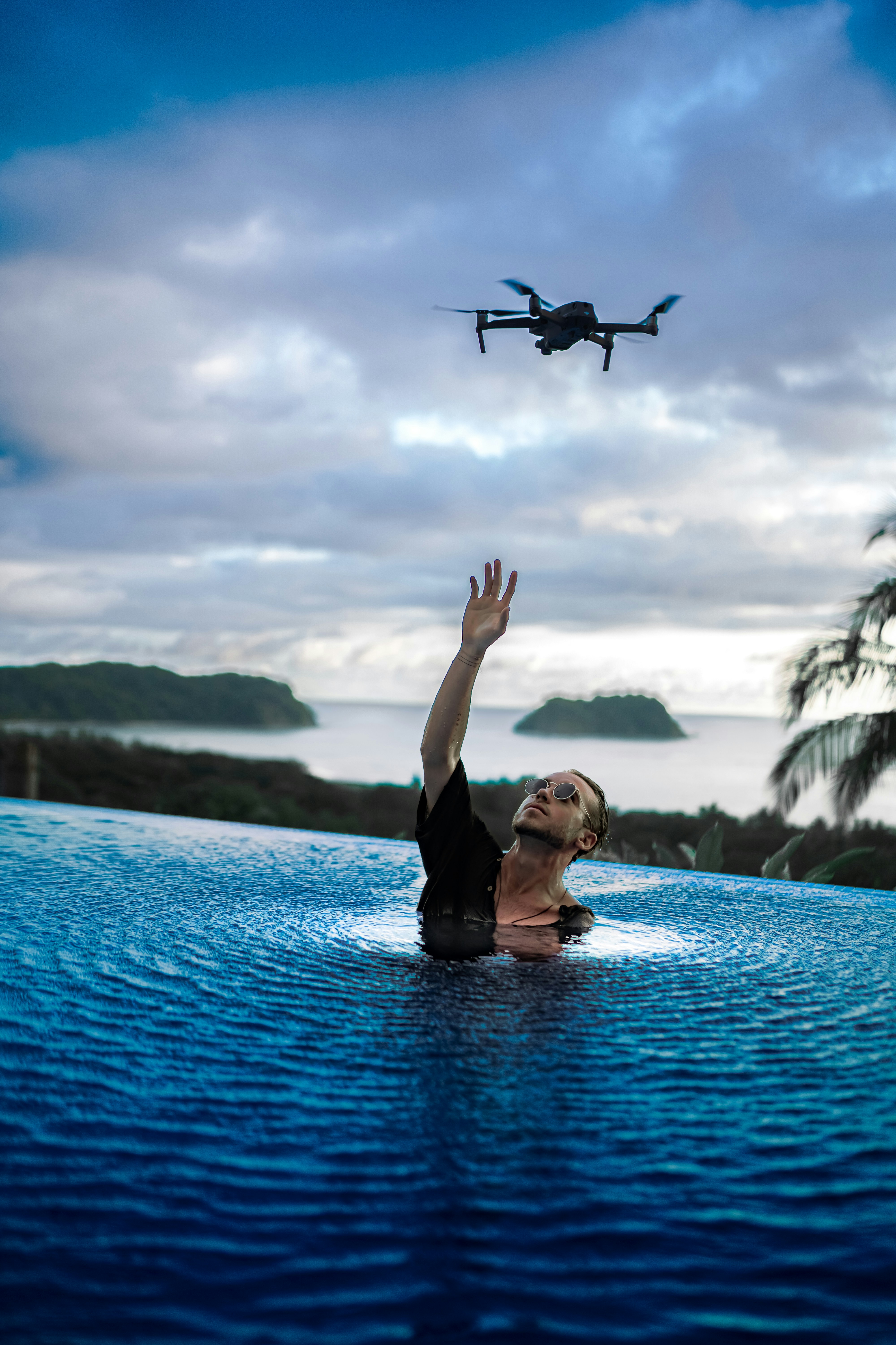 A person in a pool with a remote control plane flying overhead photo ...