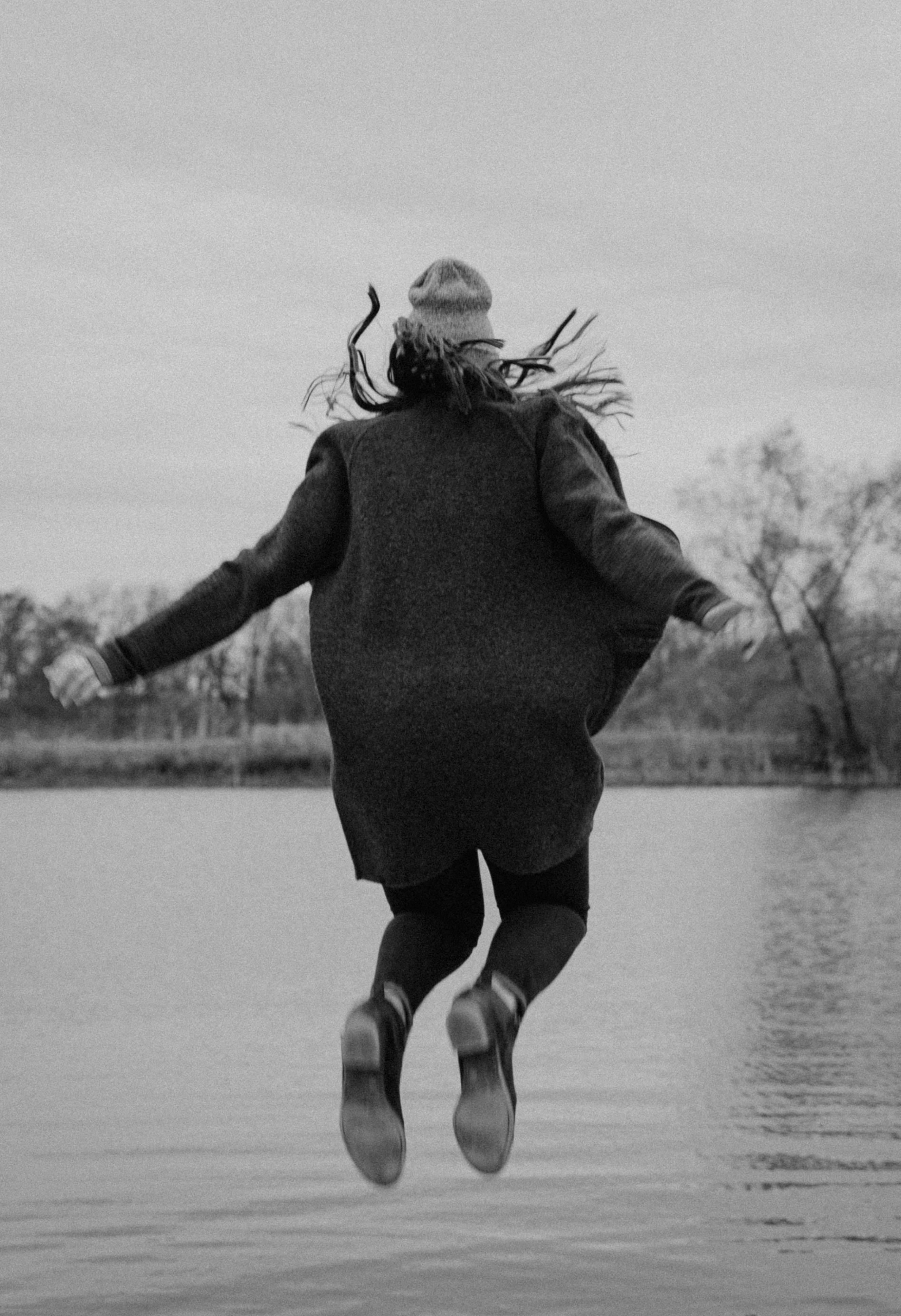 a black and white photo of a person jumping in the air