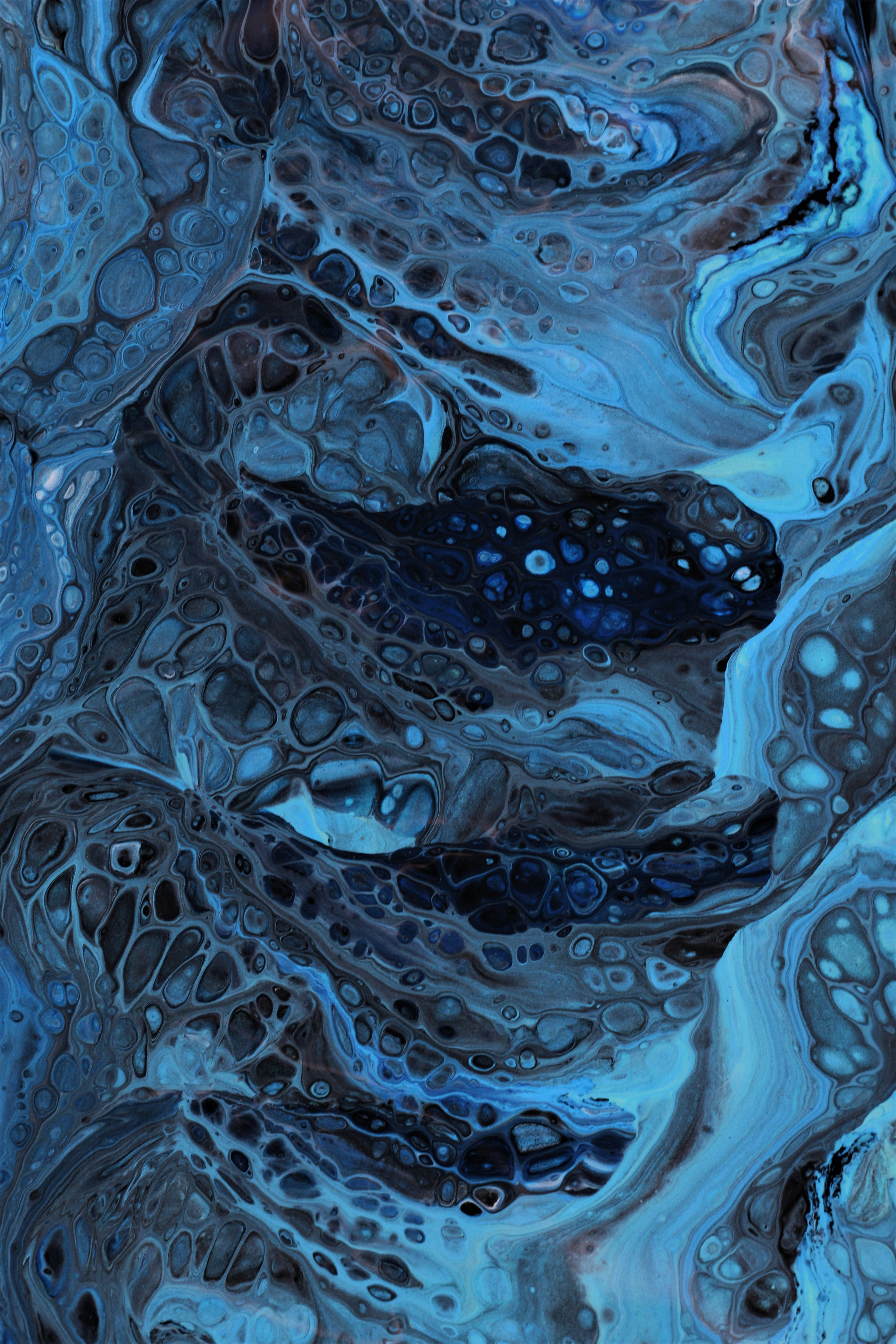 Abstract fluid art showcasing swirling shades of blue and black, evoking the depths of the ocean. The intricate patterns create a mesmerizing visual flow.