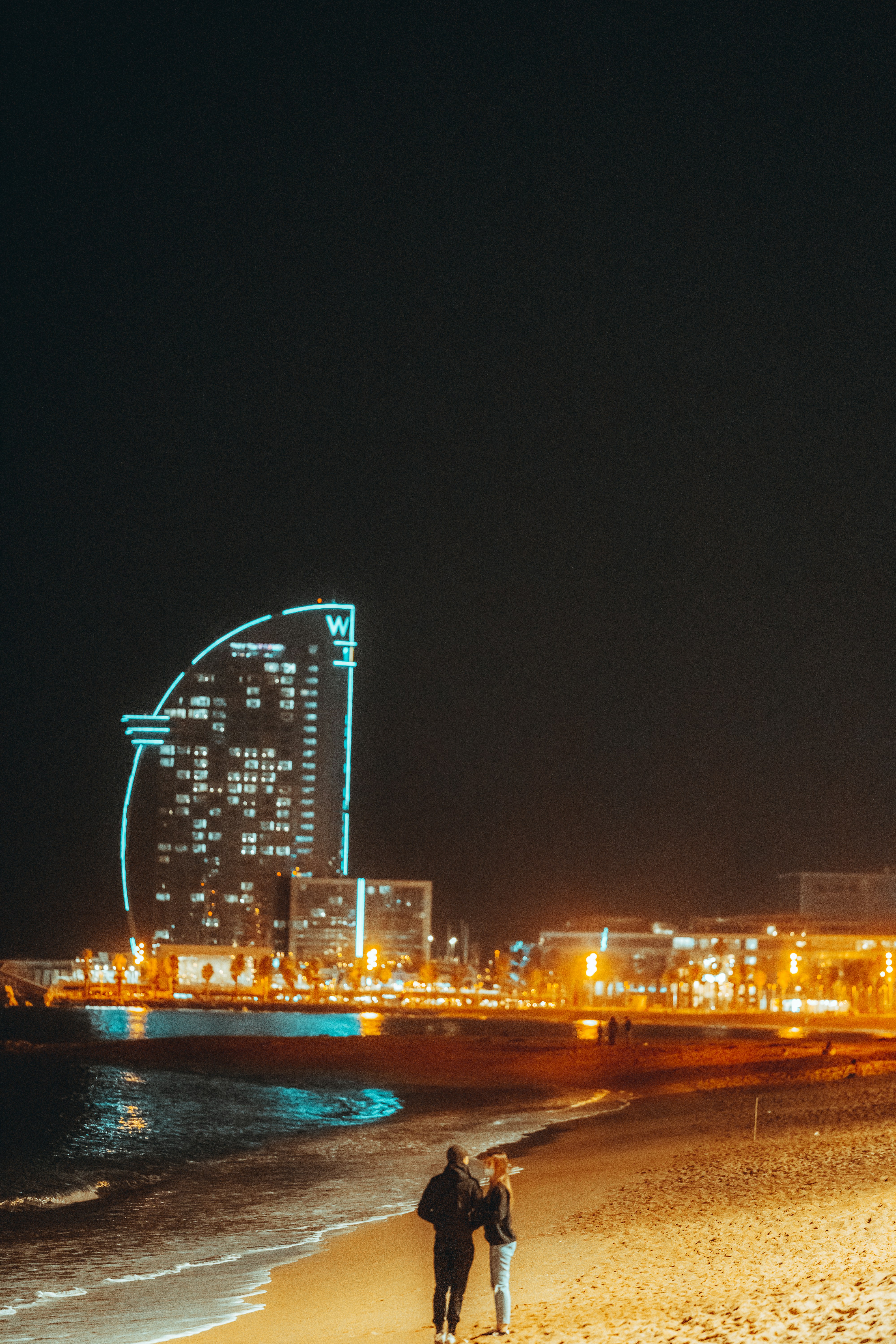 Neon Arc Over the Seafront: Night Walk Under City Lights