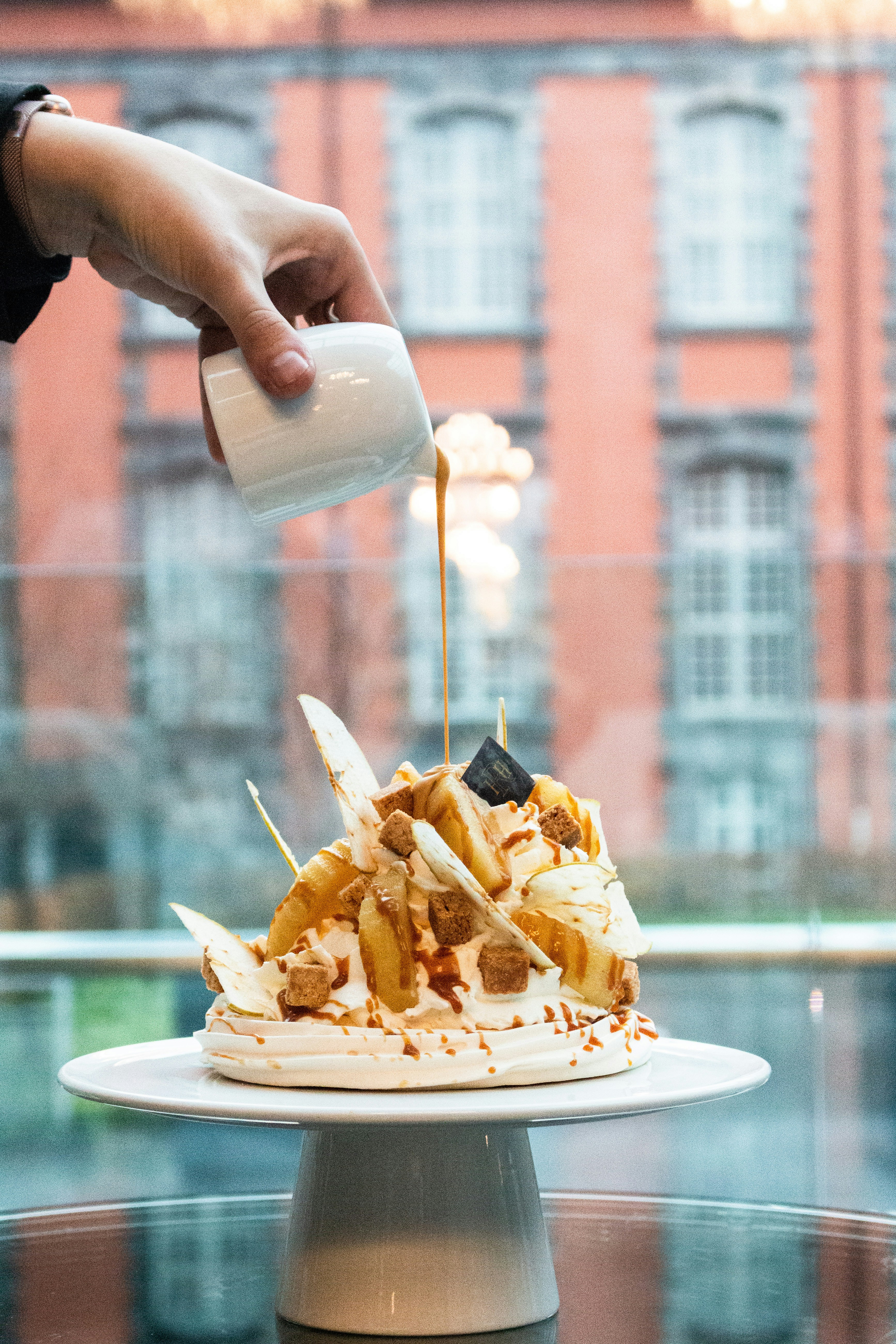 Caramel Cascade over a Creamy Crest: A Dessert Moment on Glass and Brick