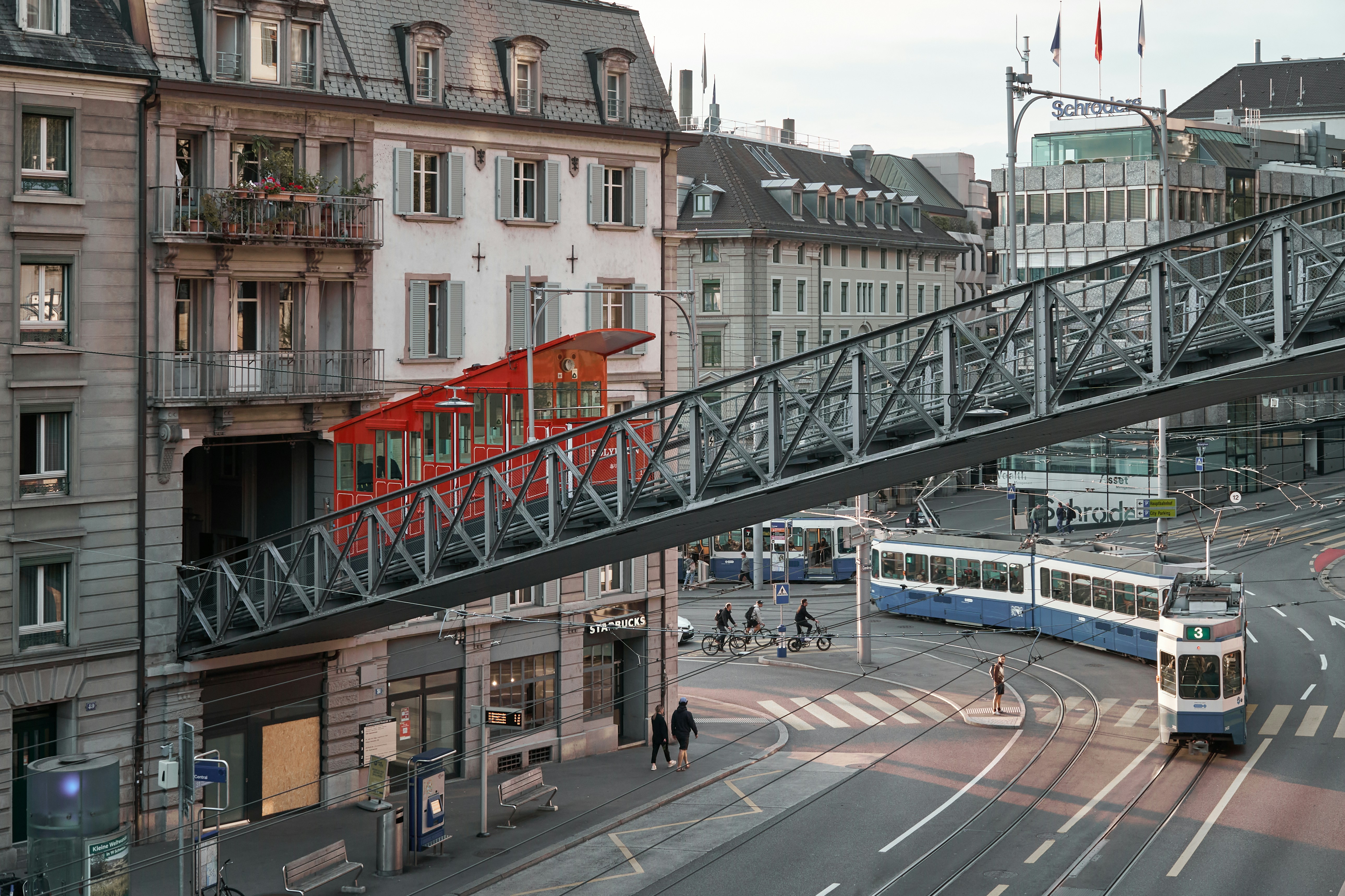 A city street with a train going under a bridge photo – Free Zürich ...