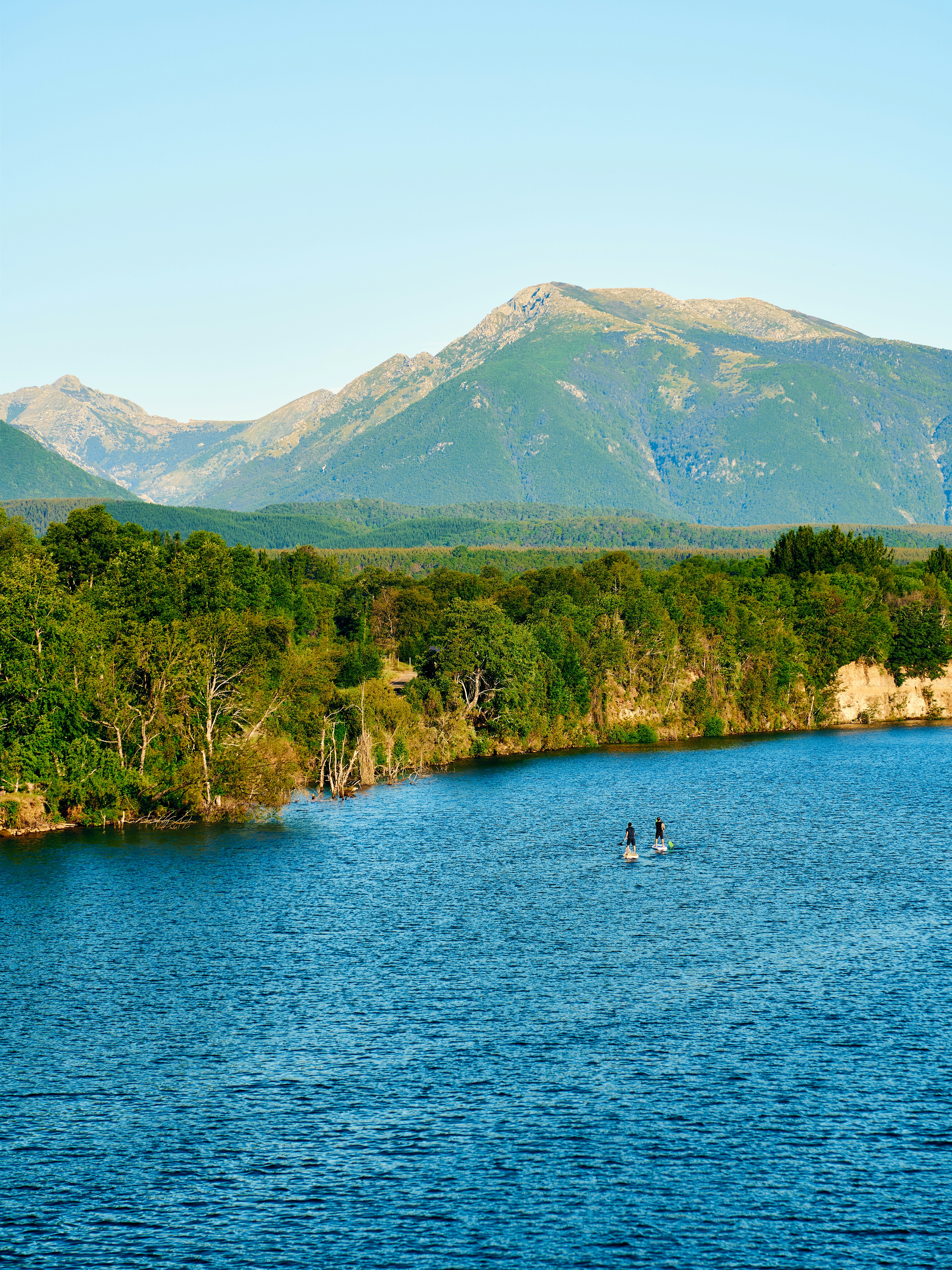 Paddlers on a Serene Alpine Lake Framed by Craggy Peaks