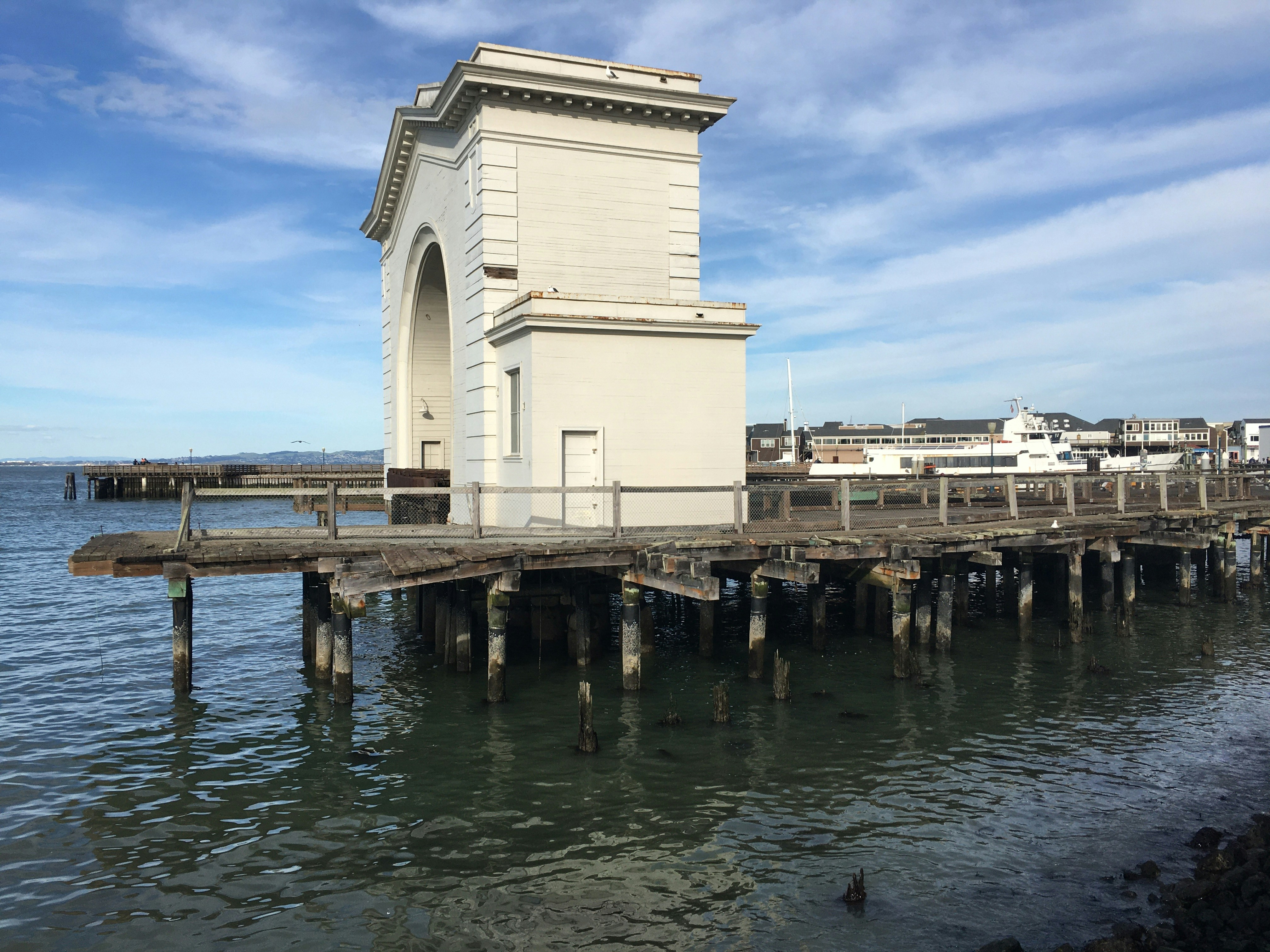 Pier Arch Emerges from Calm Waters Under a Clear Sky