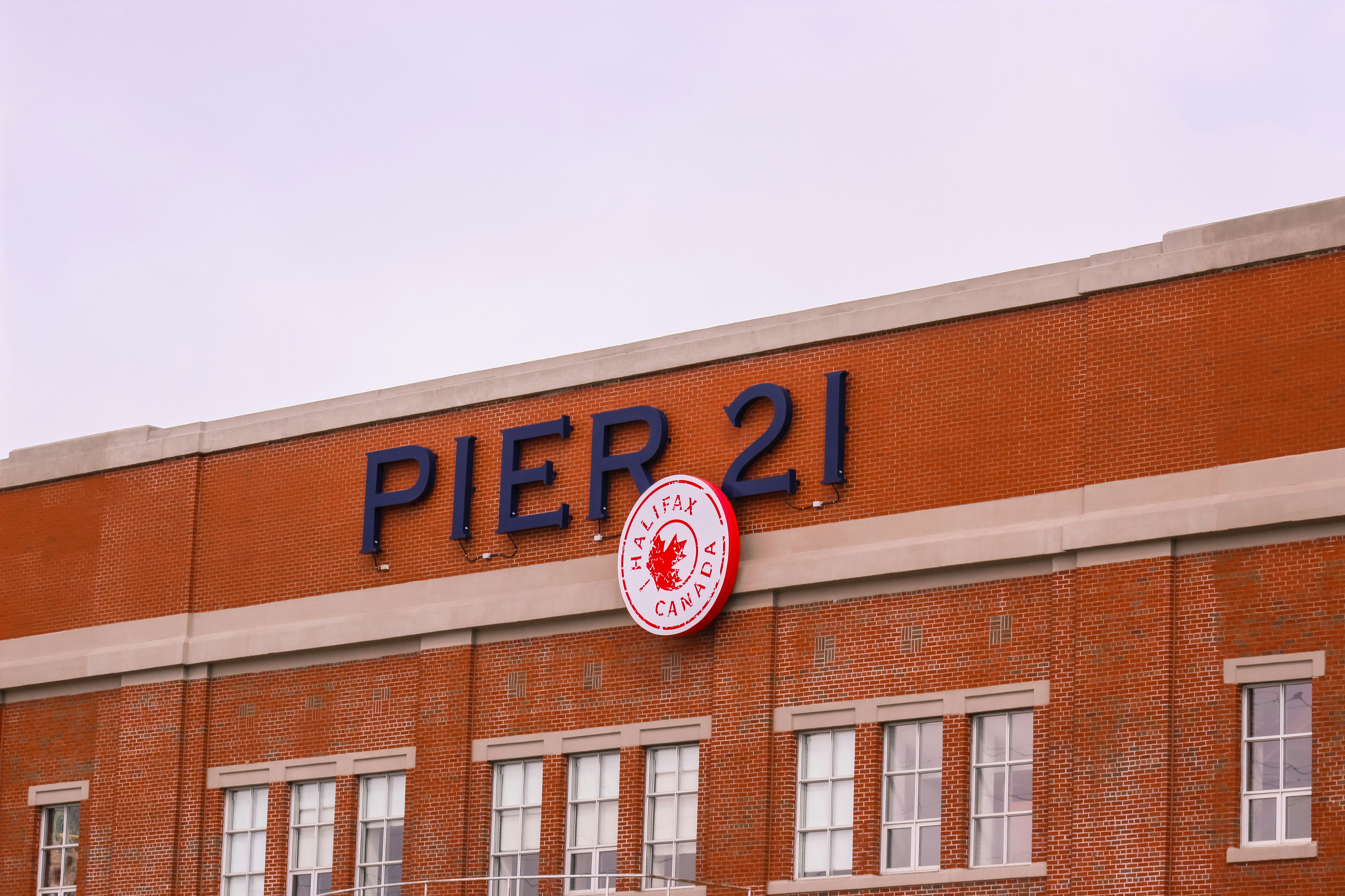 A large brick building with a clock on the front of it photo – Free ...