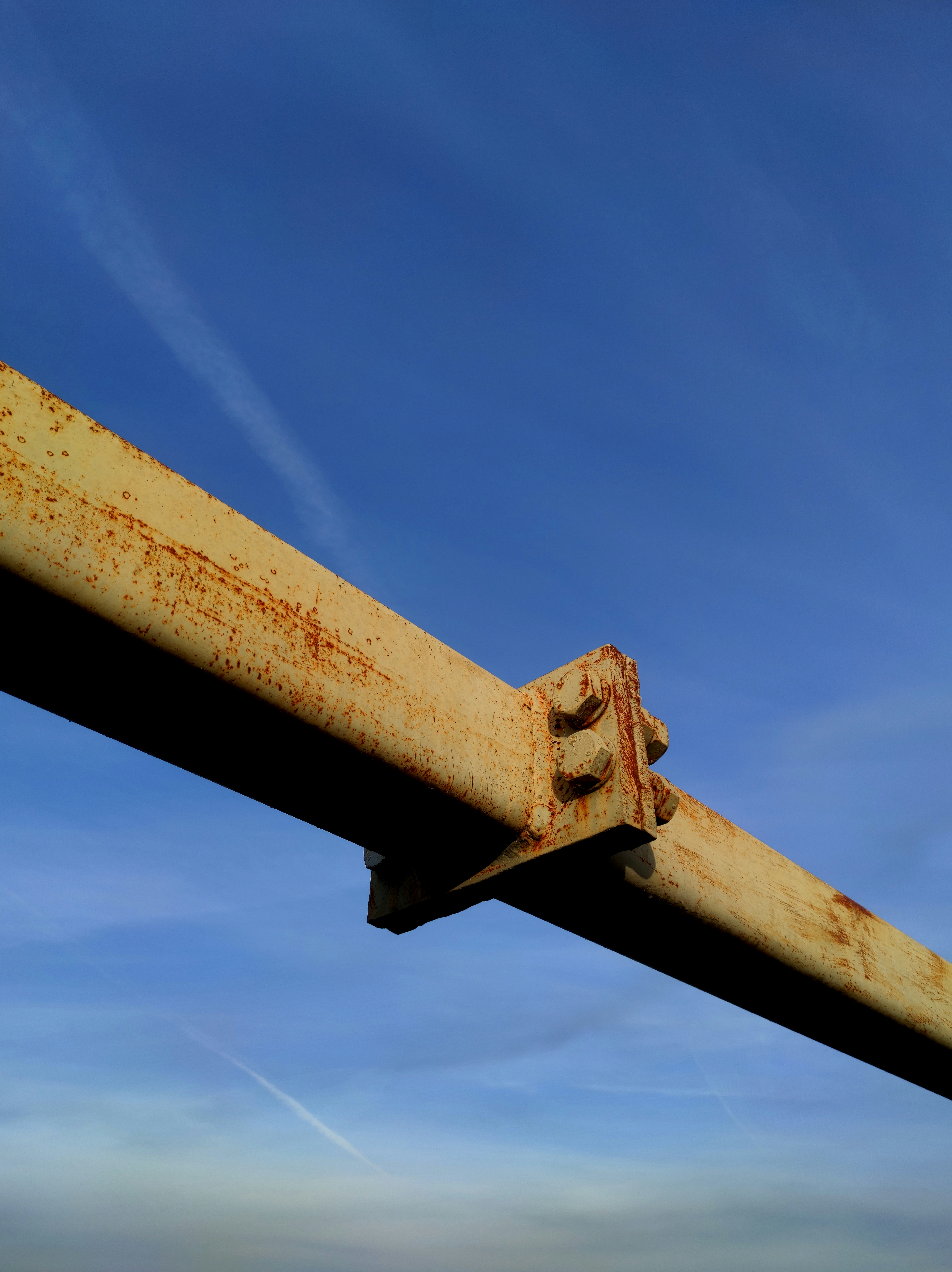 A rusted metal rail with a blue sky in the background photo – Free ...