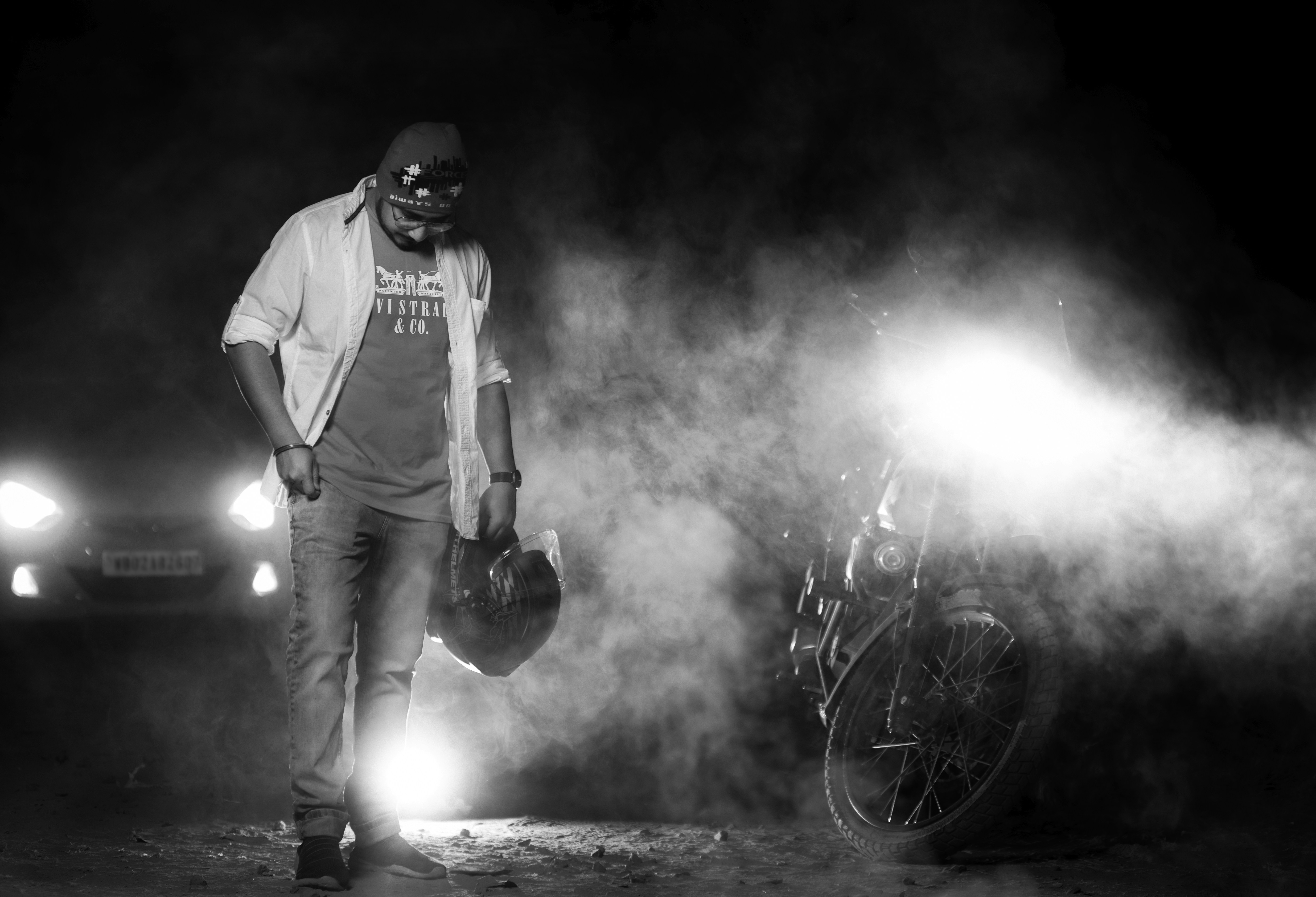 Smoky Standstill: A lone rider and bike emerge from the headlights
