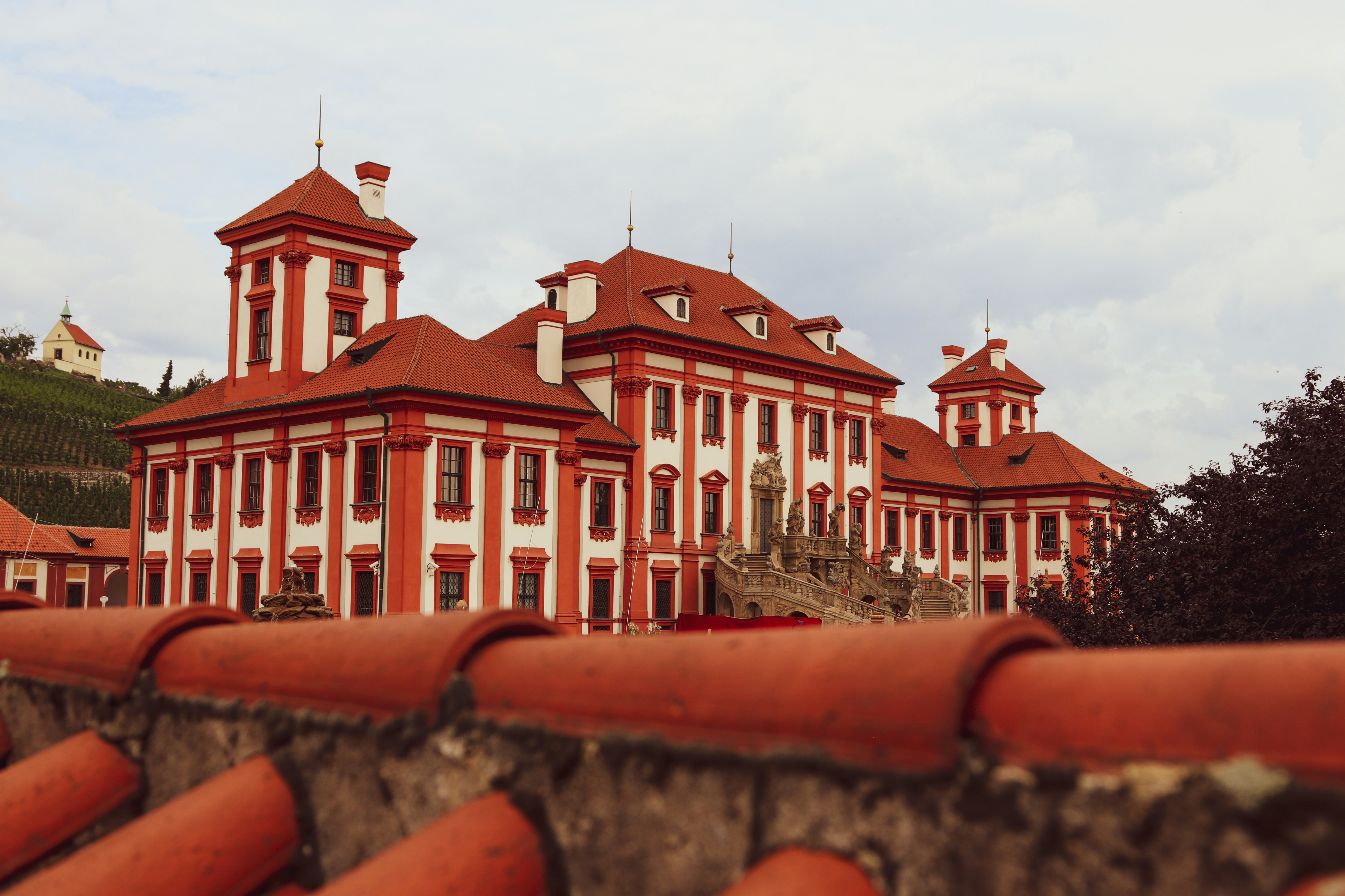 Hilltop Palace in Crimson and White, Framed by Terracotta Roofs