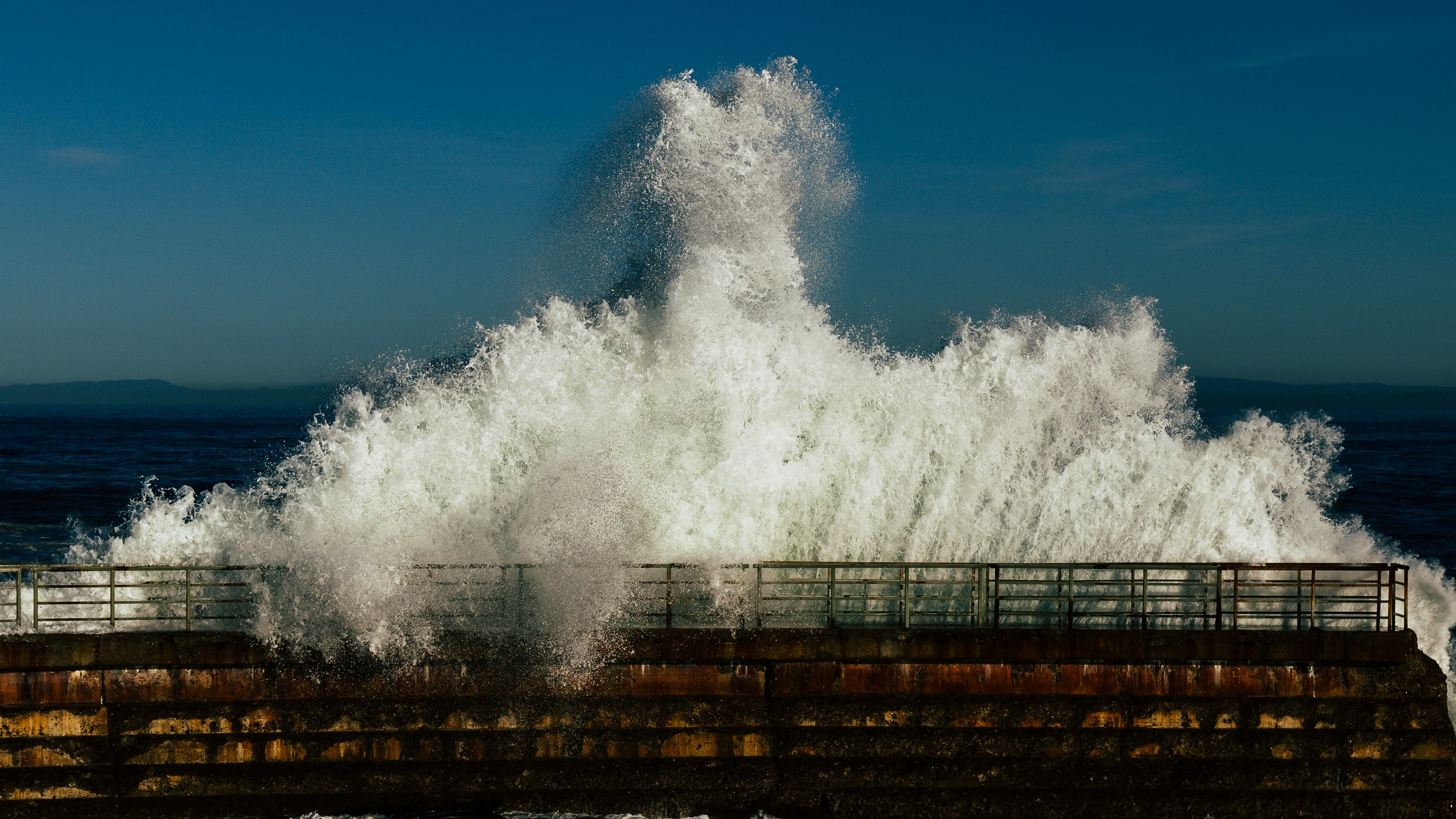 A large wave crashing over a concrete wall photo – Free Sea Image on ...