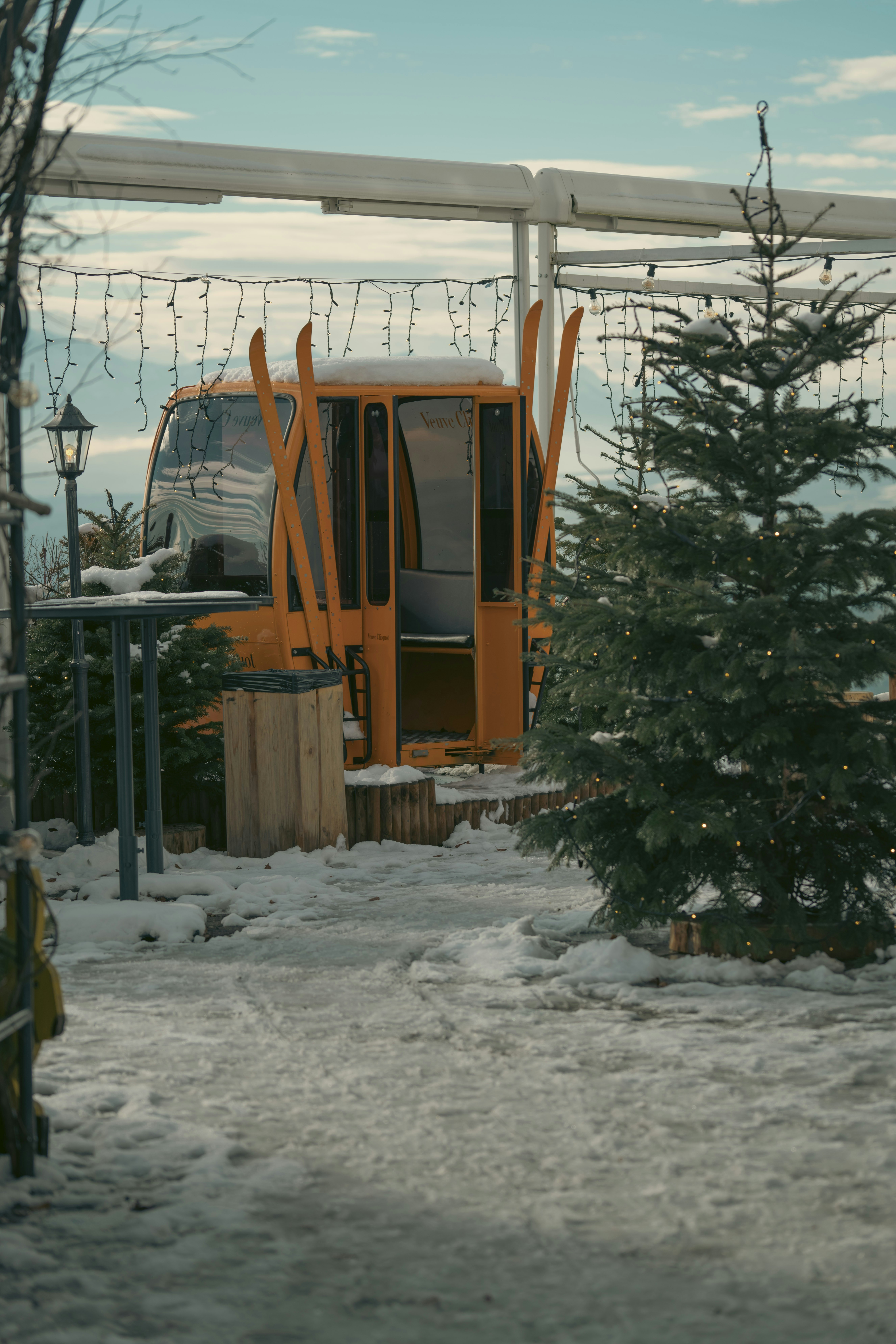 Open-Door Orange Gondola Framed by Snow and Lights