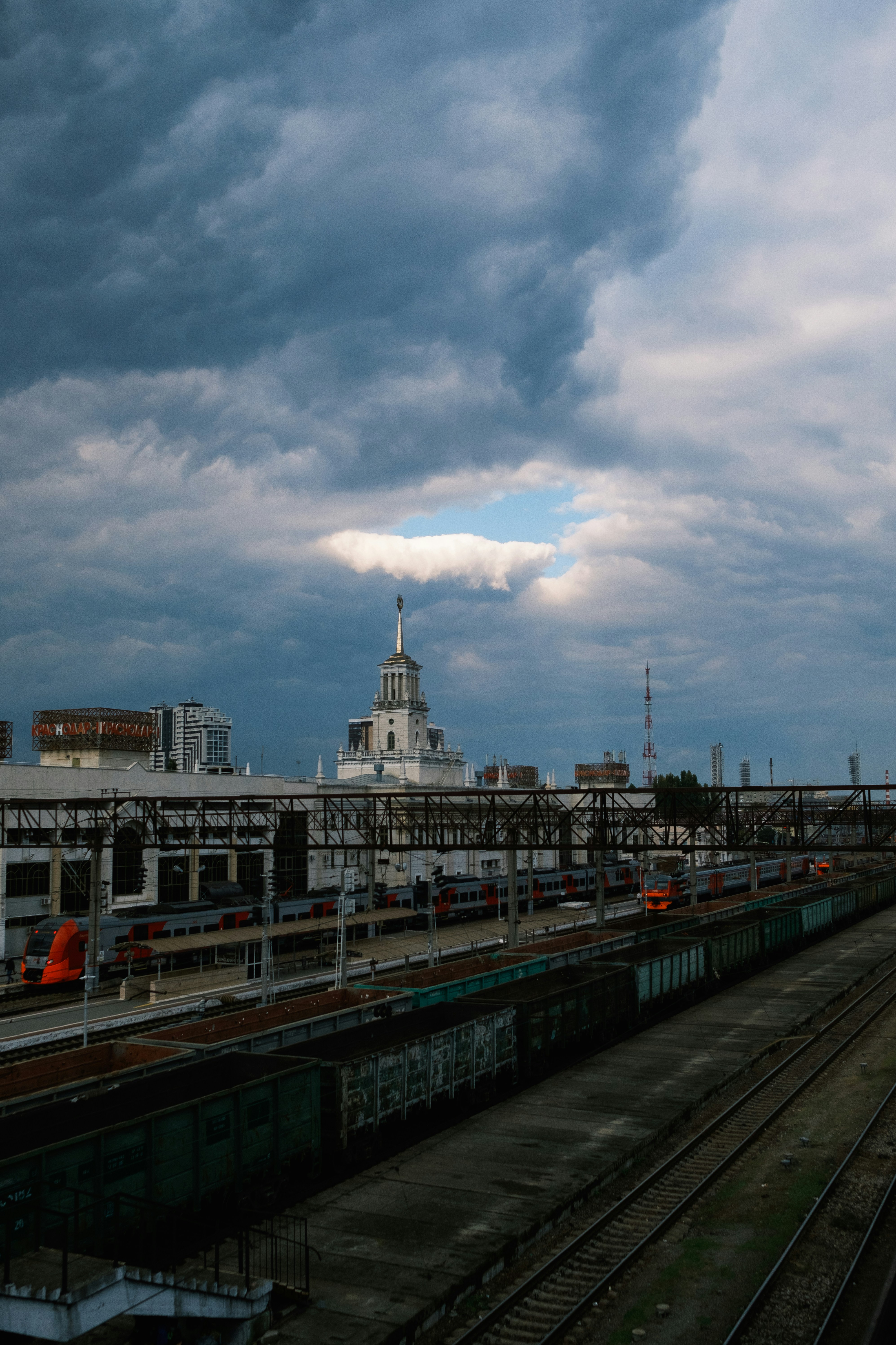Spire Over Rails: A City Skyline Beneath Moody Skies