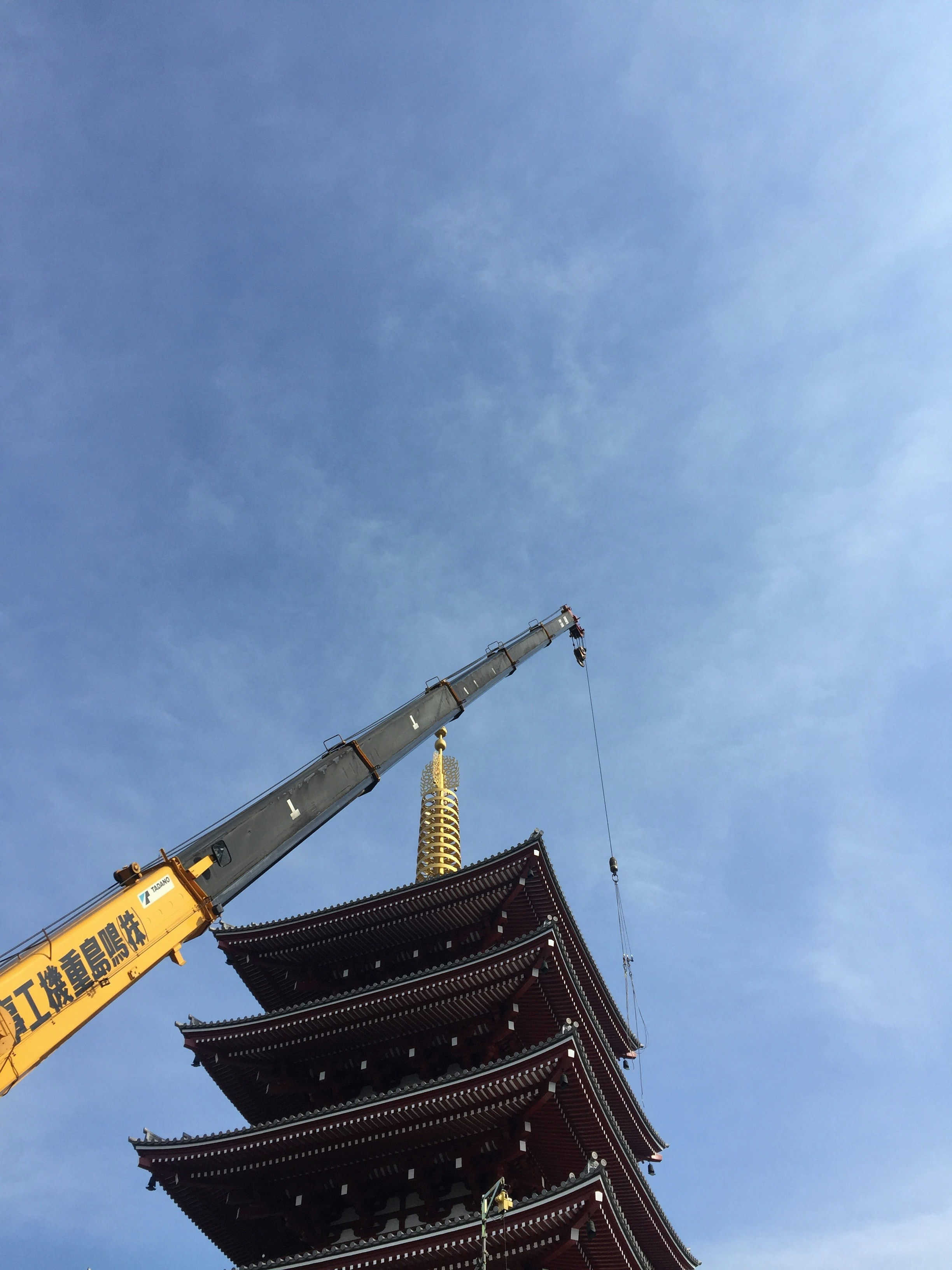 a crane is lifting a tall tower into the air