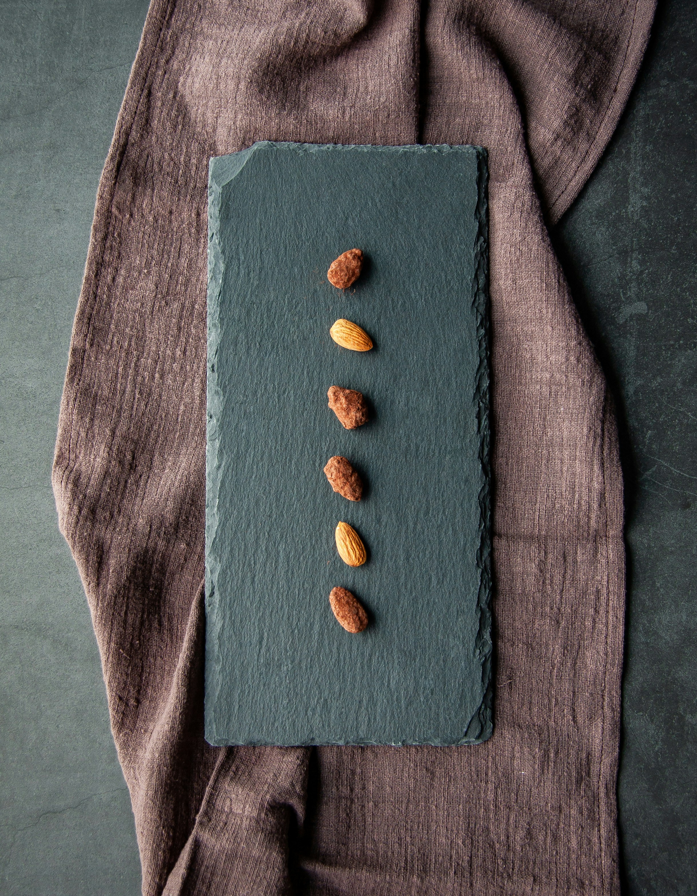 Vertical Nut Line on Charcoal Slate: A Quiet Food Study