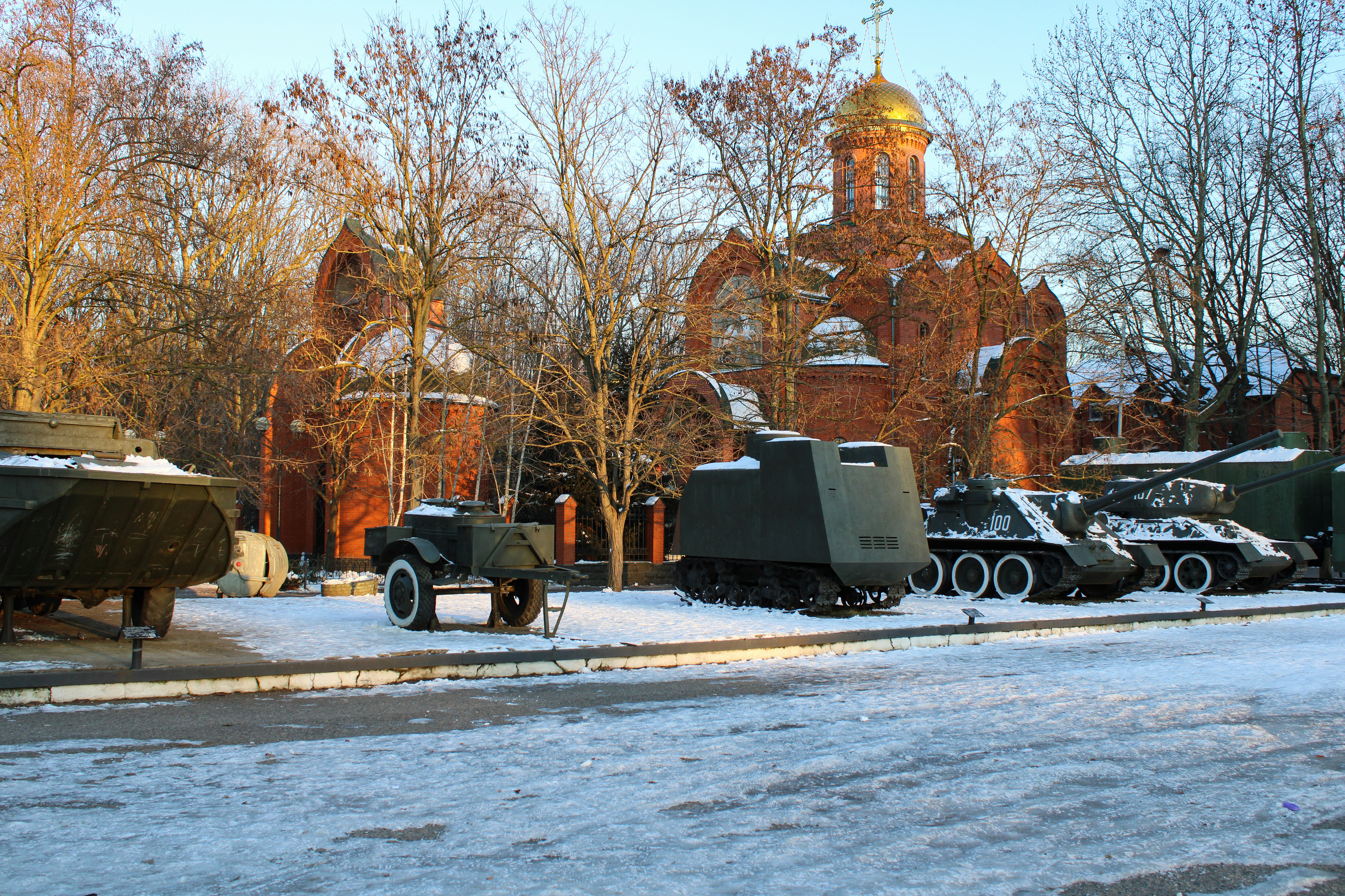 Snow-Lined Armored Row Before a Gold-Domed Red Brick Church