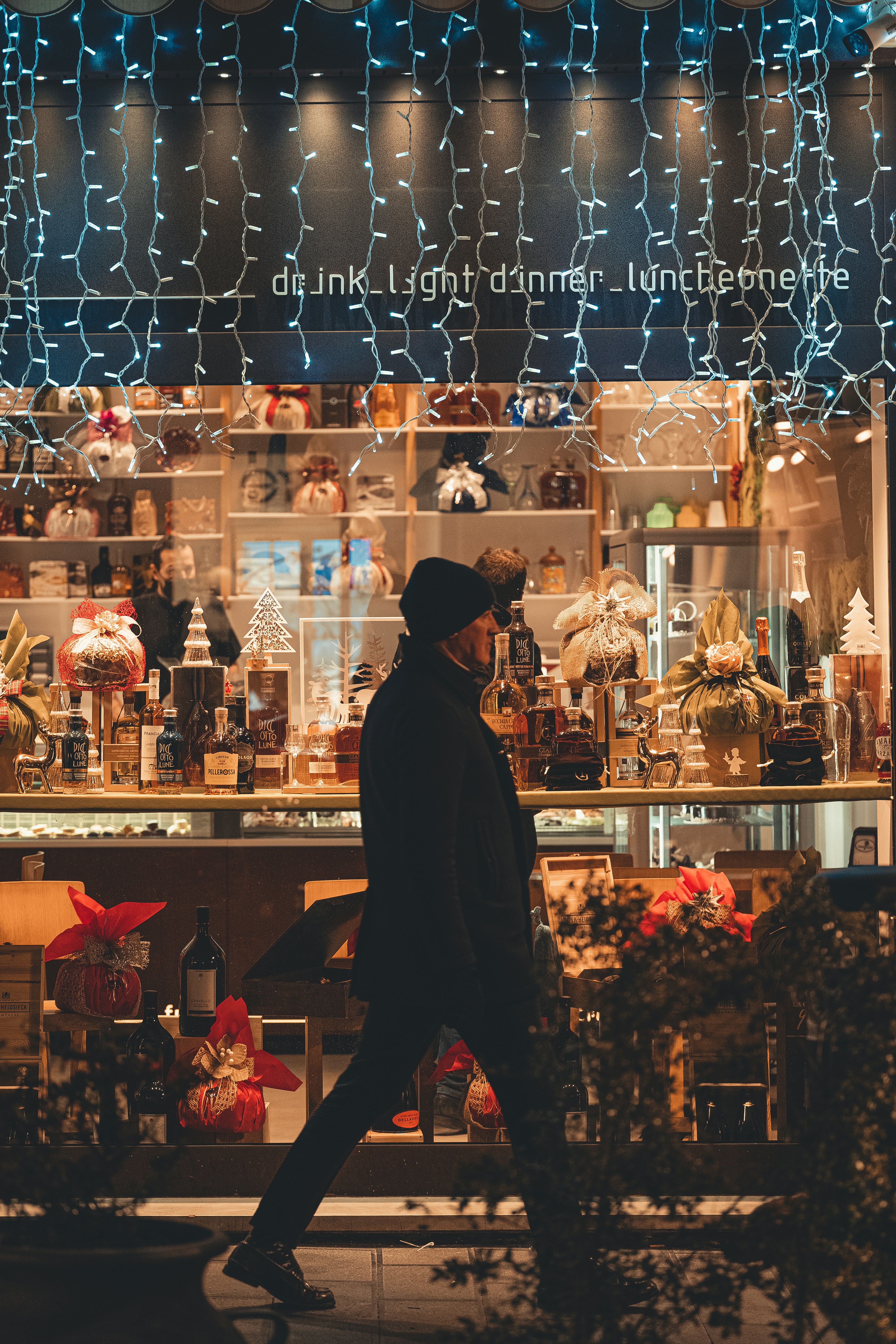 A man walking past a store front at night photo – Free Catanzaro Image ...