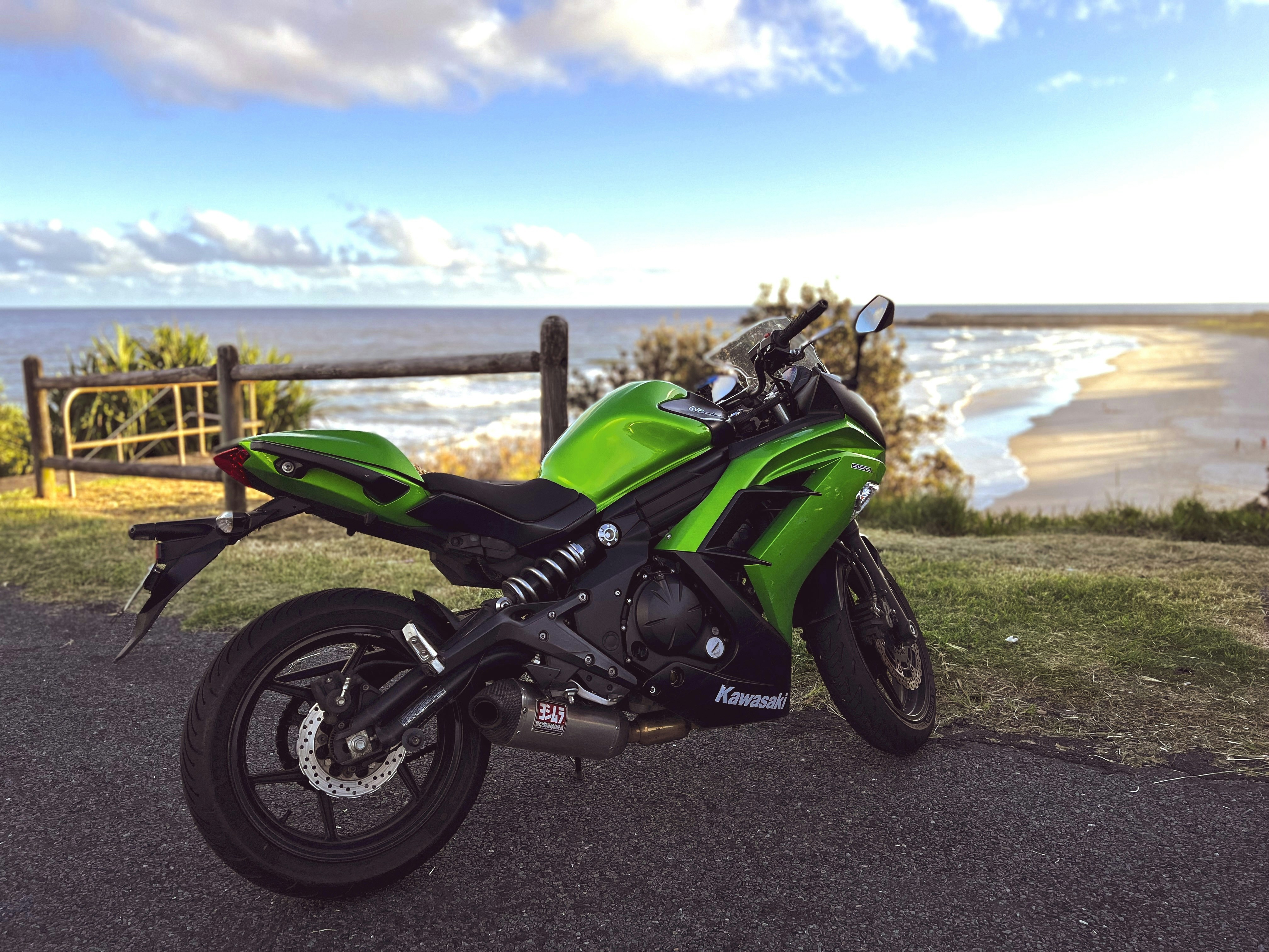 Une moto verte garée sur le bord d’une route photo – Photo 오토바이 ...